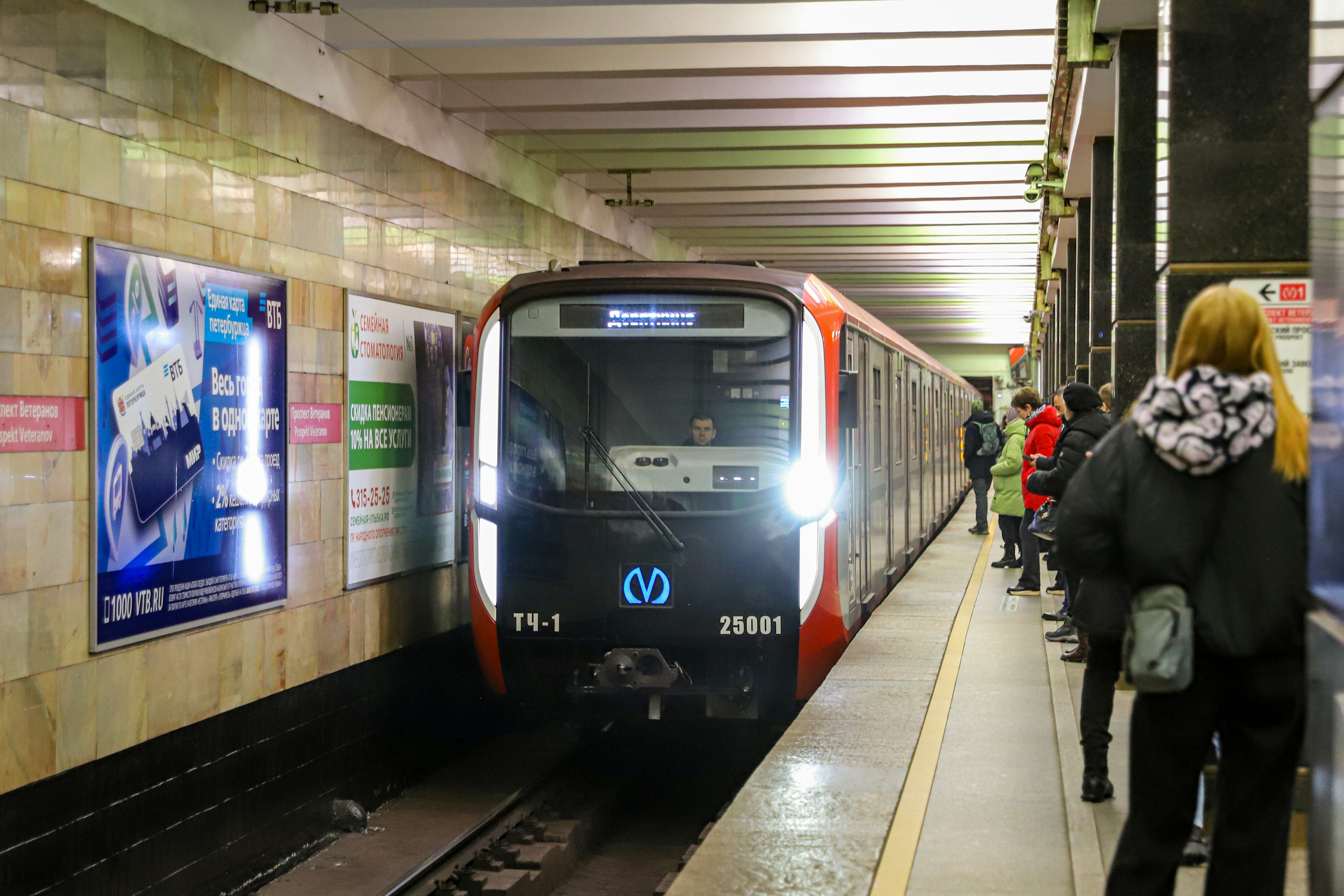 A train pulling into a train station next to a crowd of people photo ...