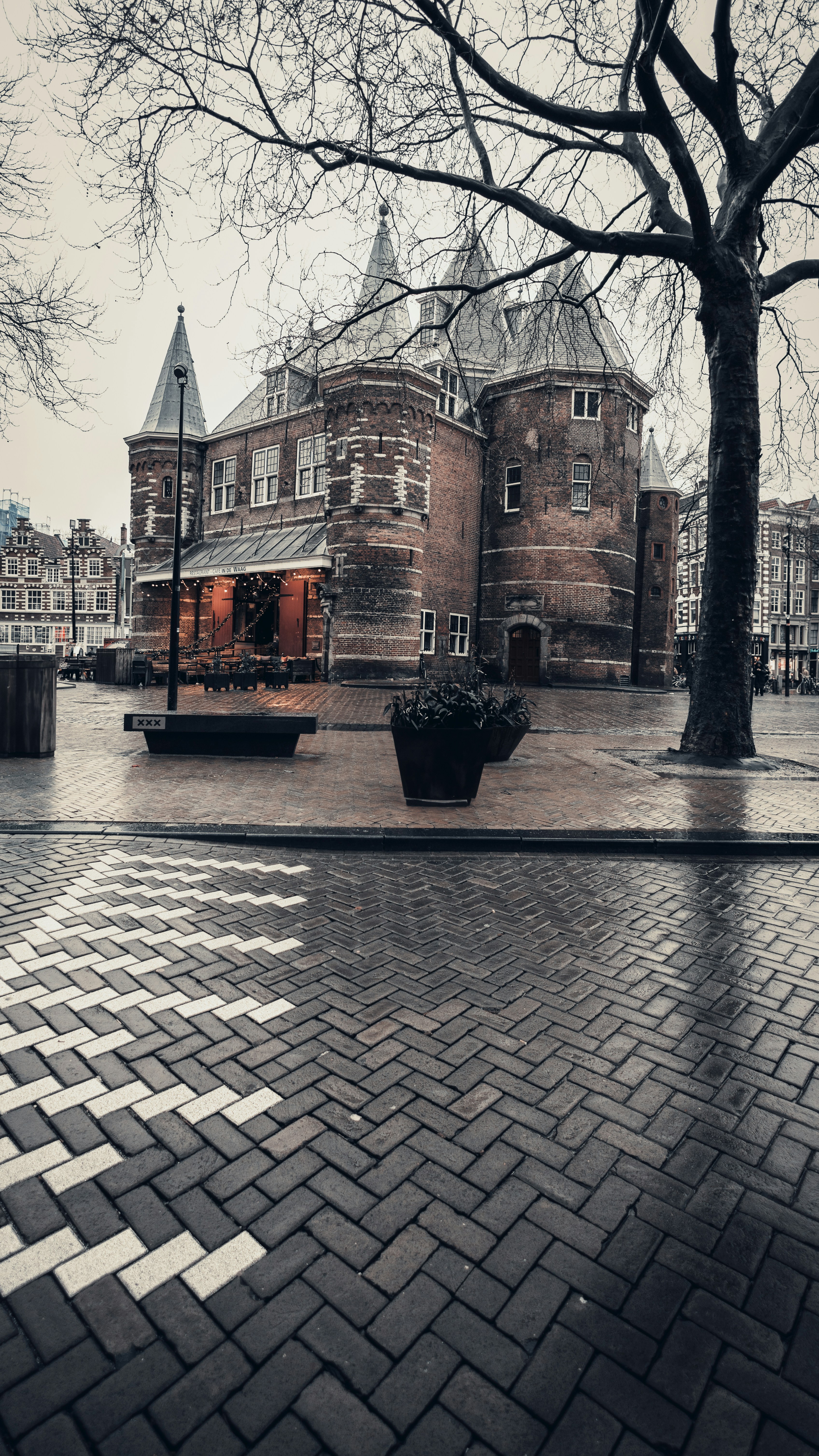 Twin-Turret Brick Gatehouse Quietly Watches a Rain-Washed European Square