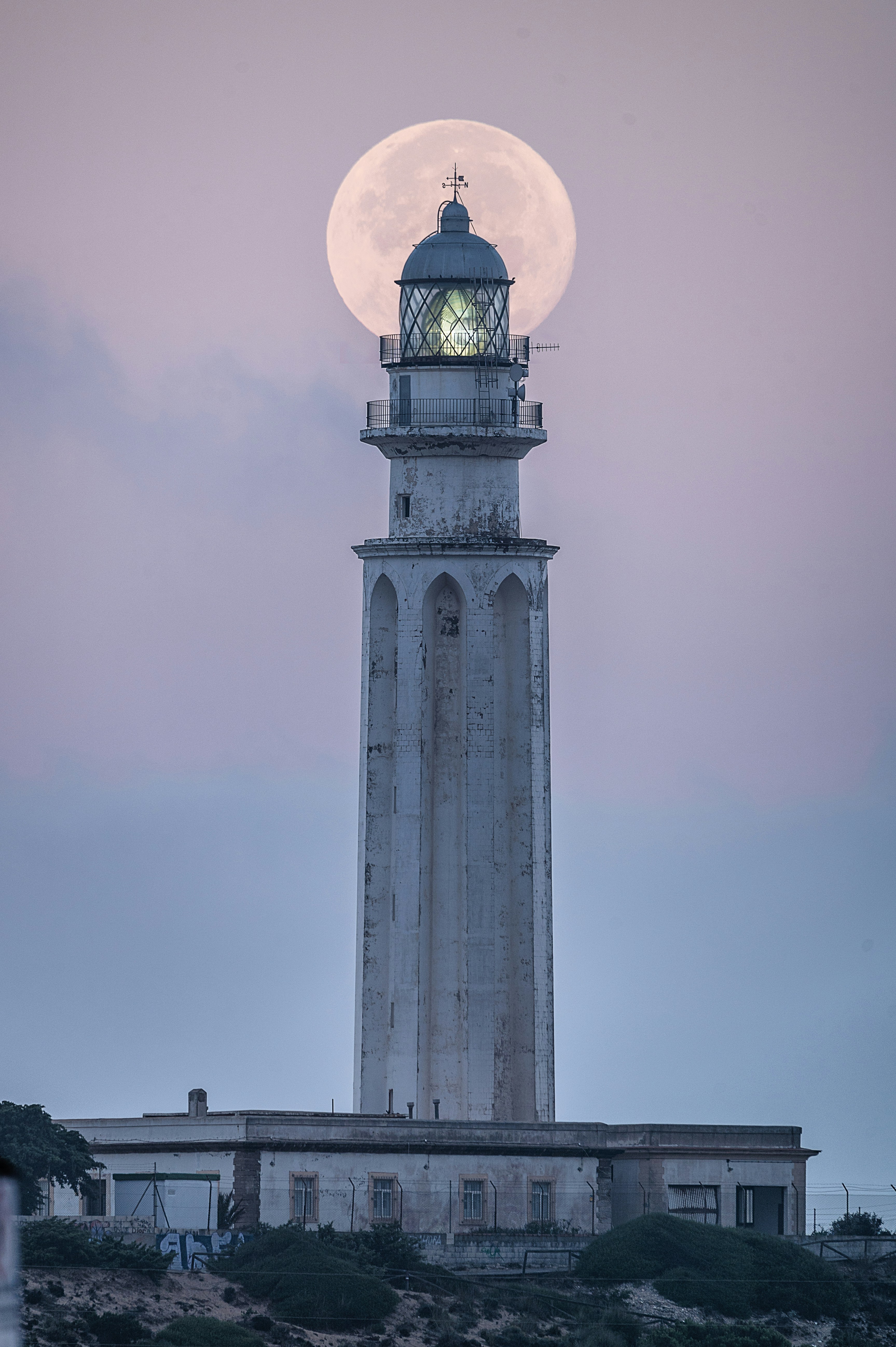 A lighthouse with a full moon in the background photo – Free Lighthouse ...