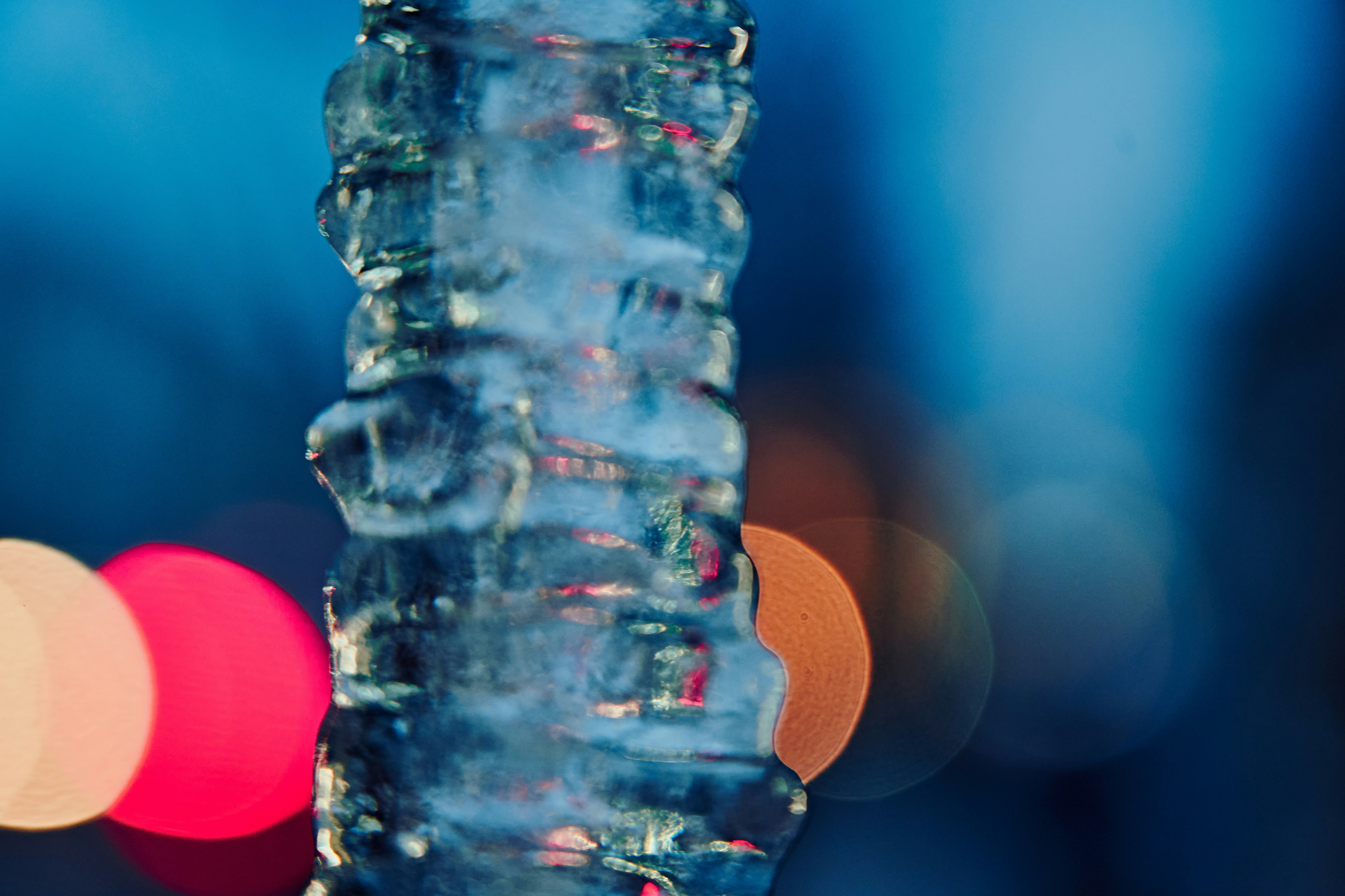 Icy Spiral: Close-Up of a Frosted Helix Against Bokeh City Lights