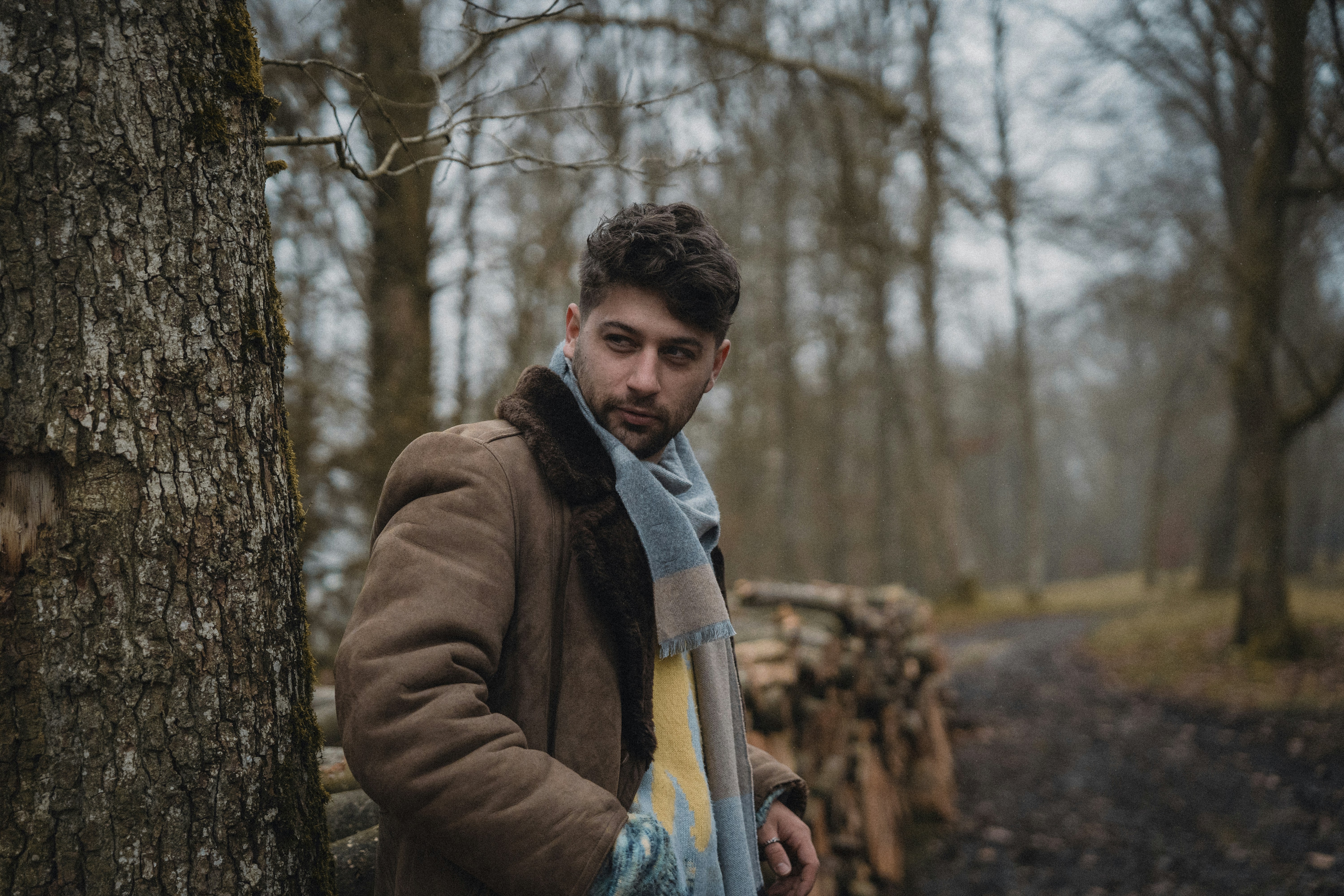 Quiet Resolve: A Man in Tan Coat Pauses by Winter's Trail