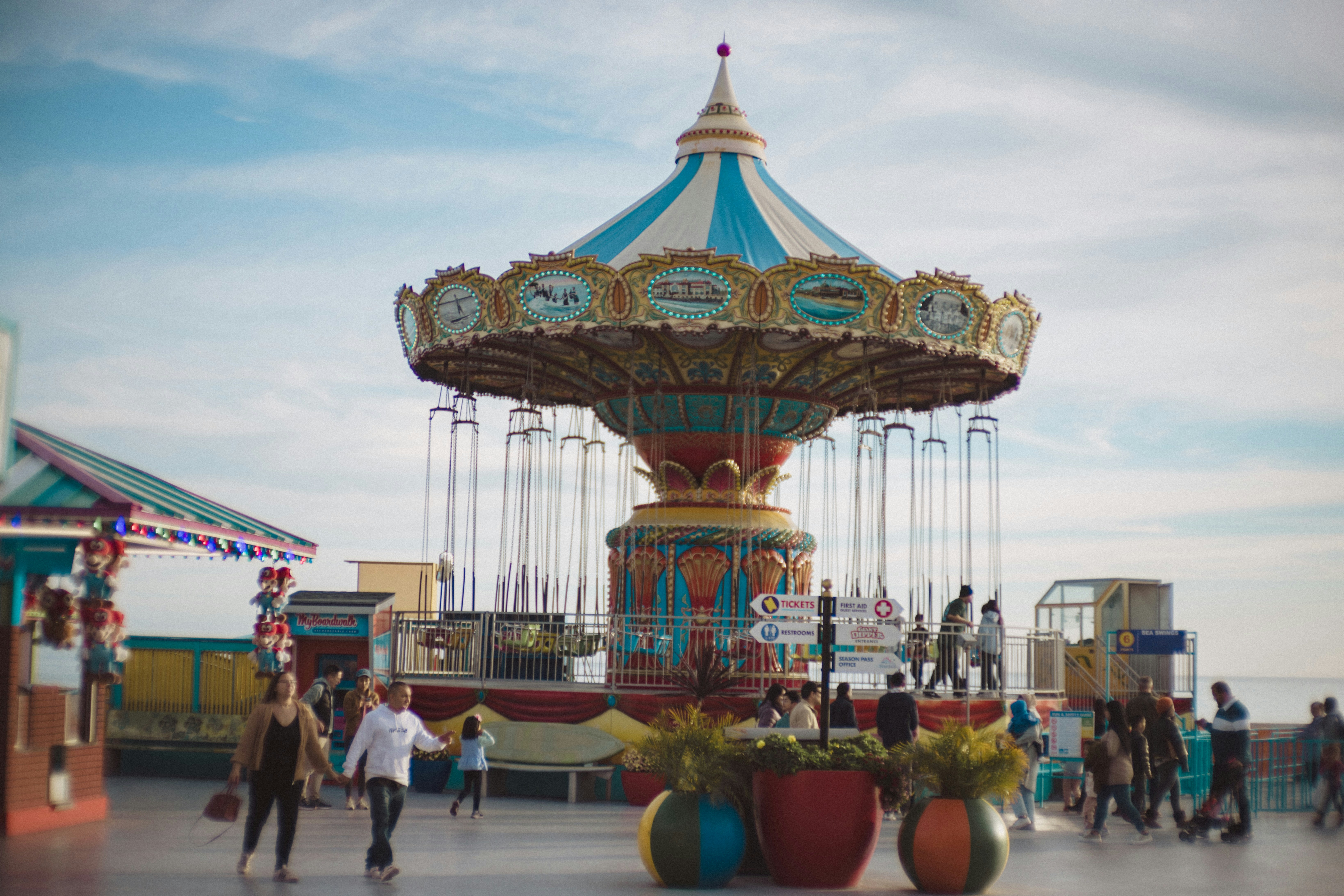 A merry go round with people walking around it photo – Free Building ...