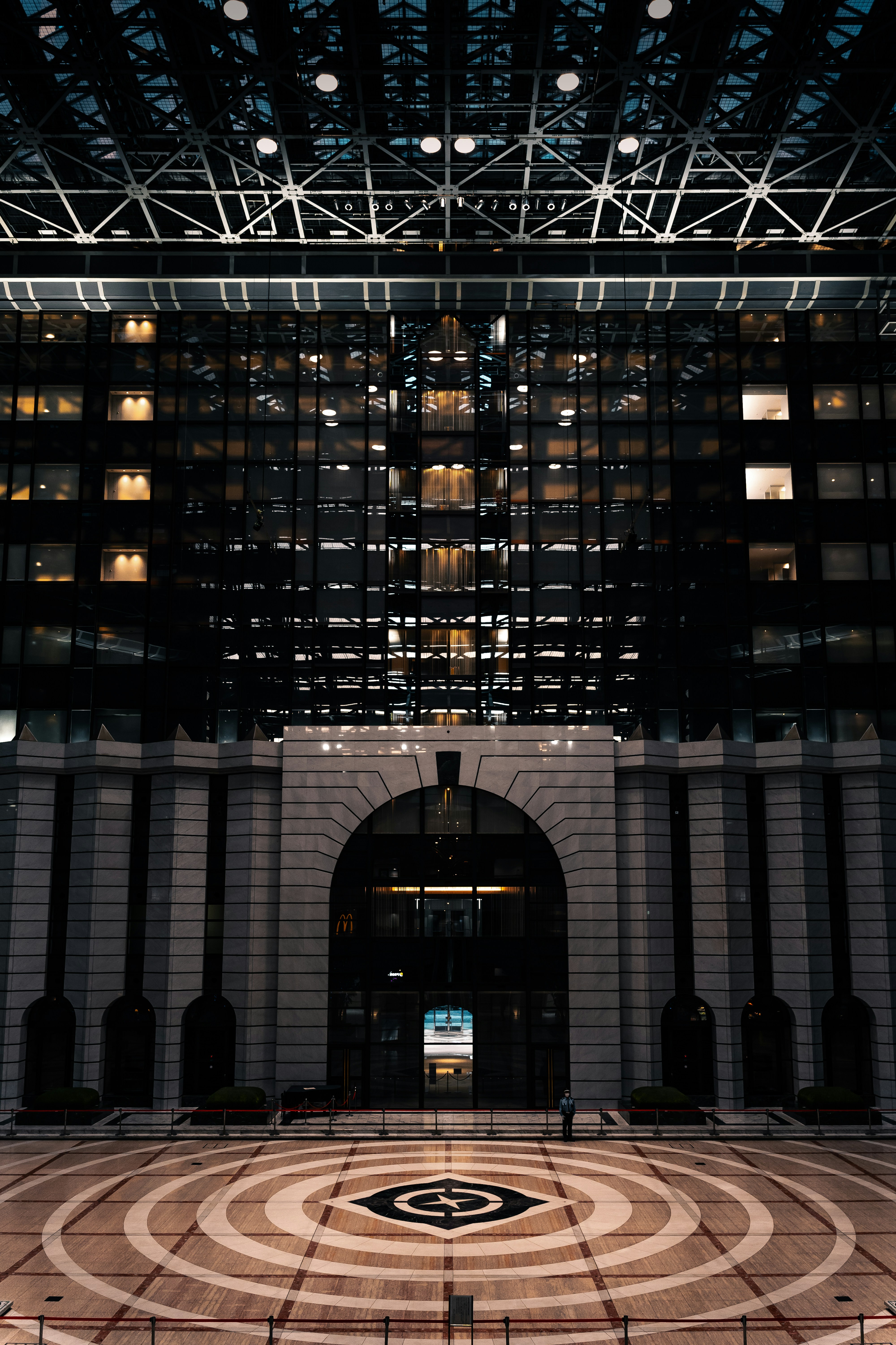 Central Arch in a Lattice of Light: Nighttime Facade Above a Concentric Plaza