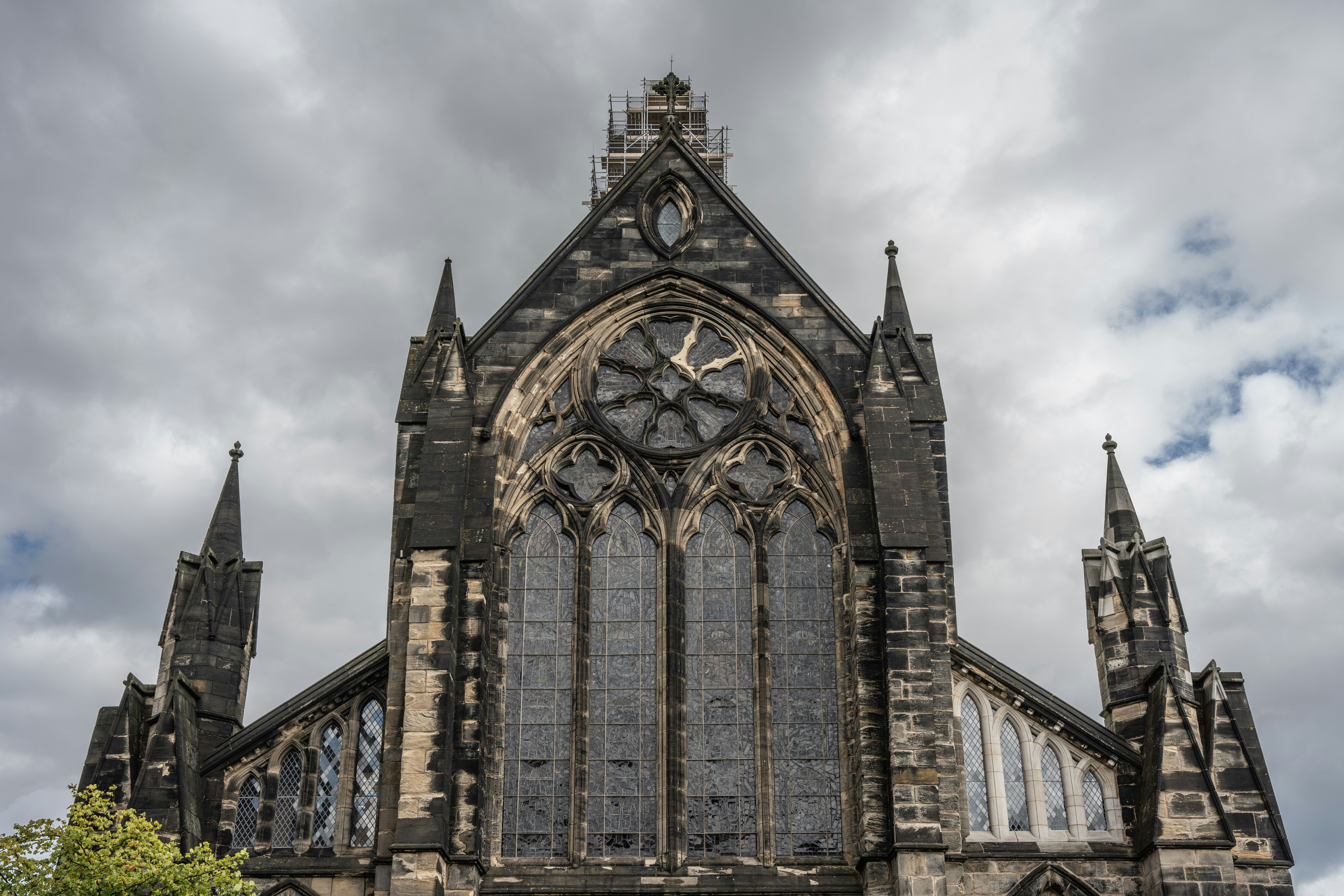Gothic cathedral facade with intricate stonework under a cloudy sky.