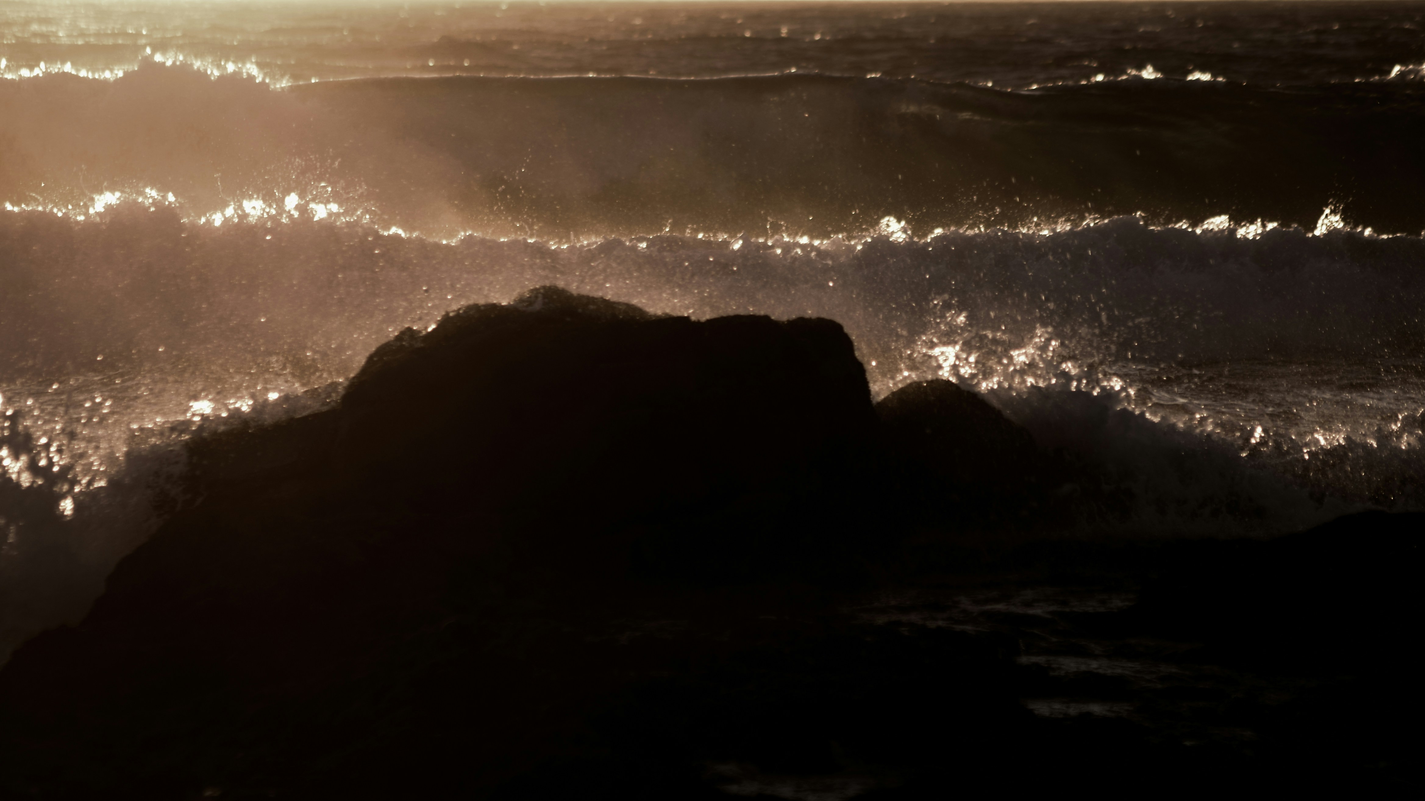 Dusk Breakers: Waves Silhouetted on Quiet Rocks