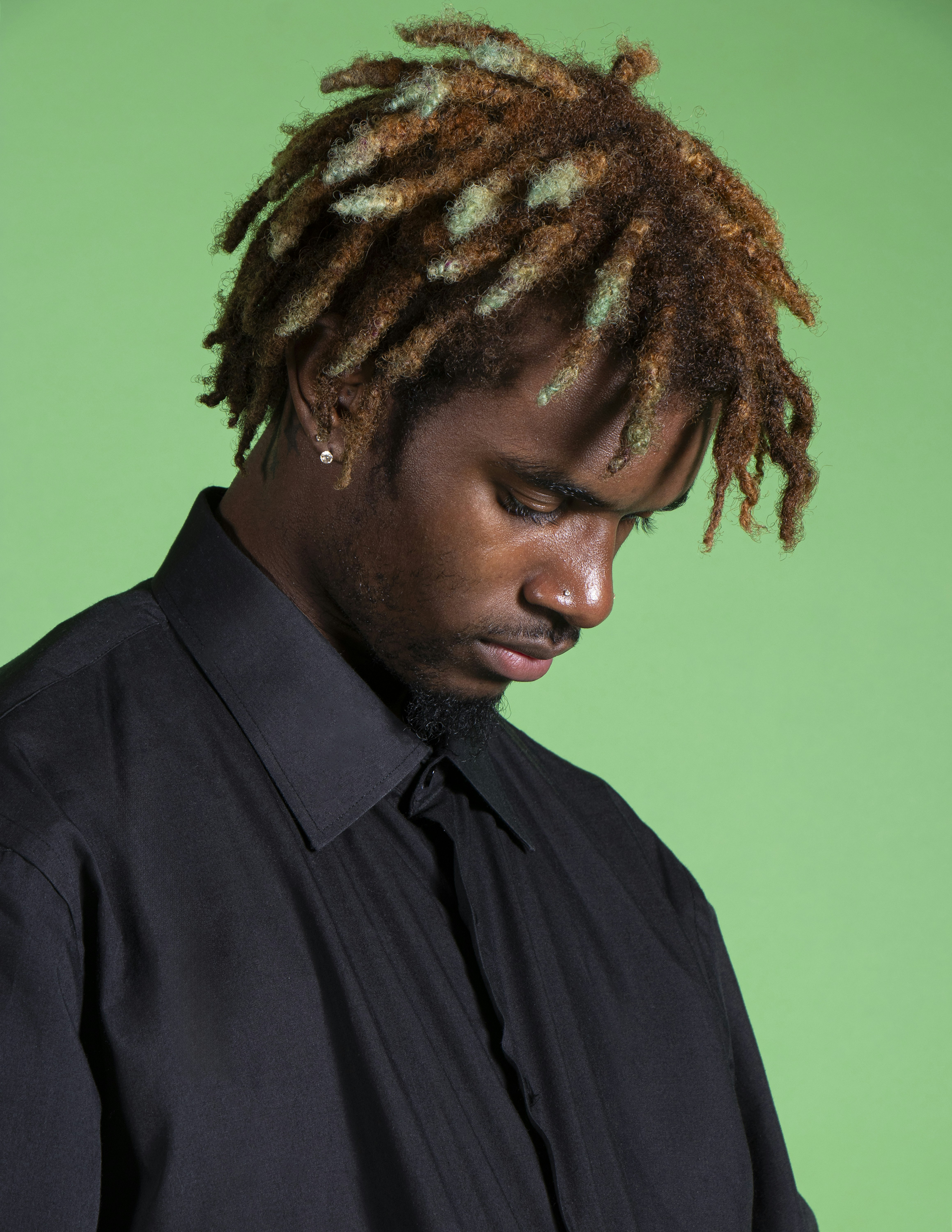 Contemplative Portrait in Black Against a Fresh Green Studio Backdrop