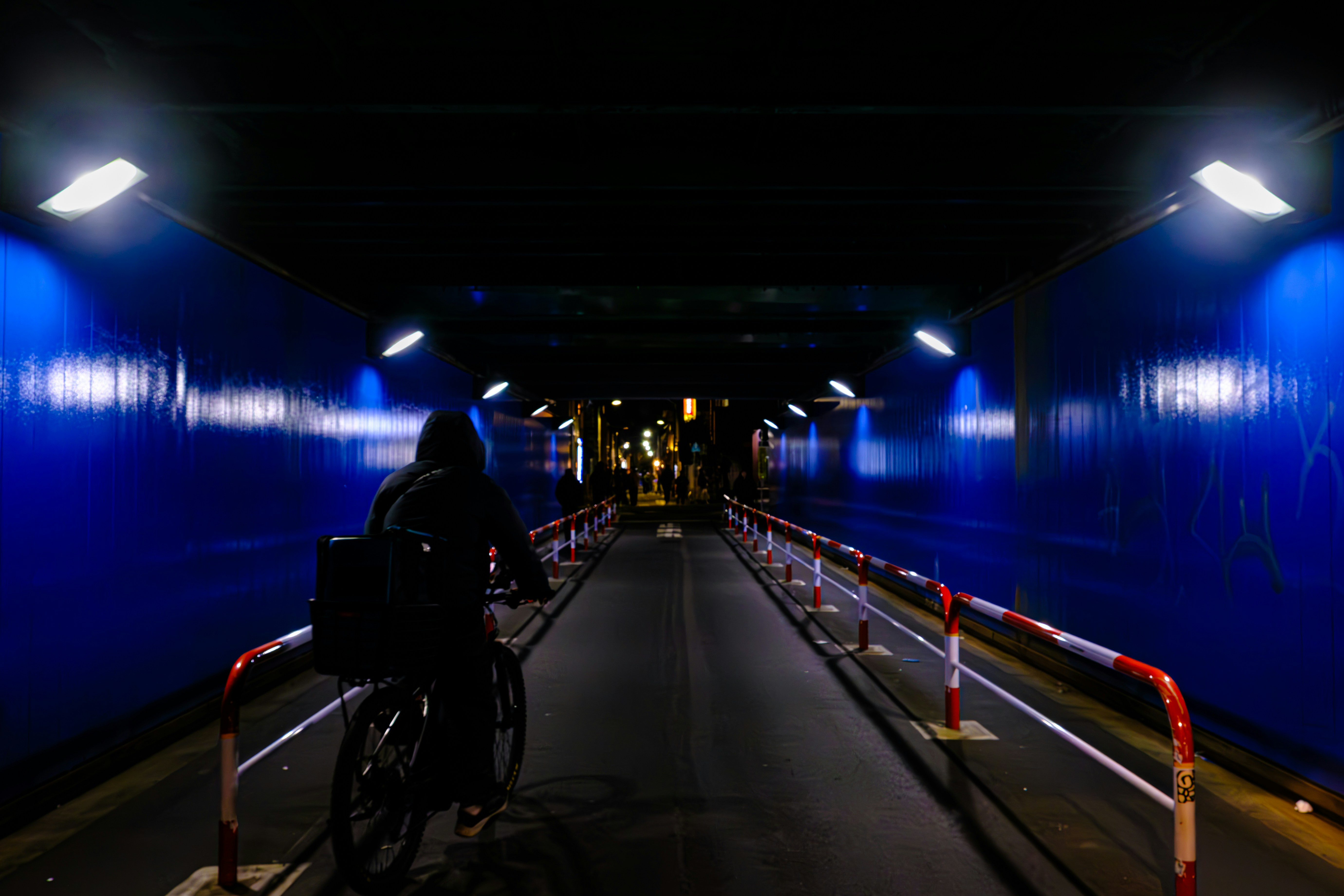 Neon Blue Corridor: A Cyclist in the Underpass