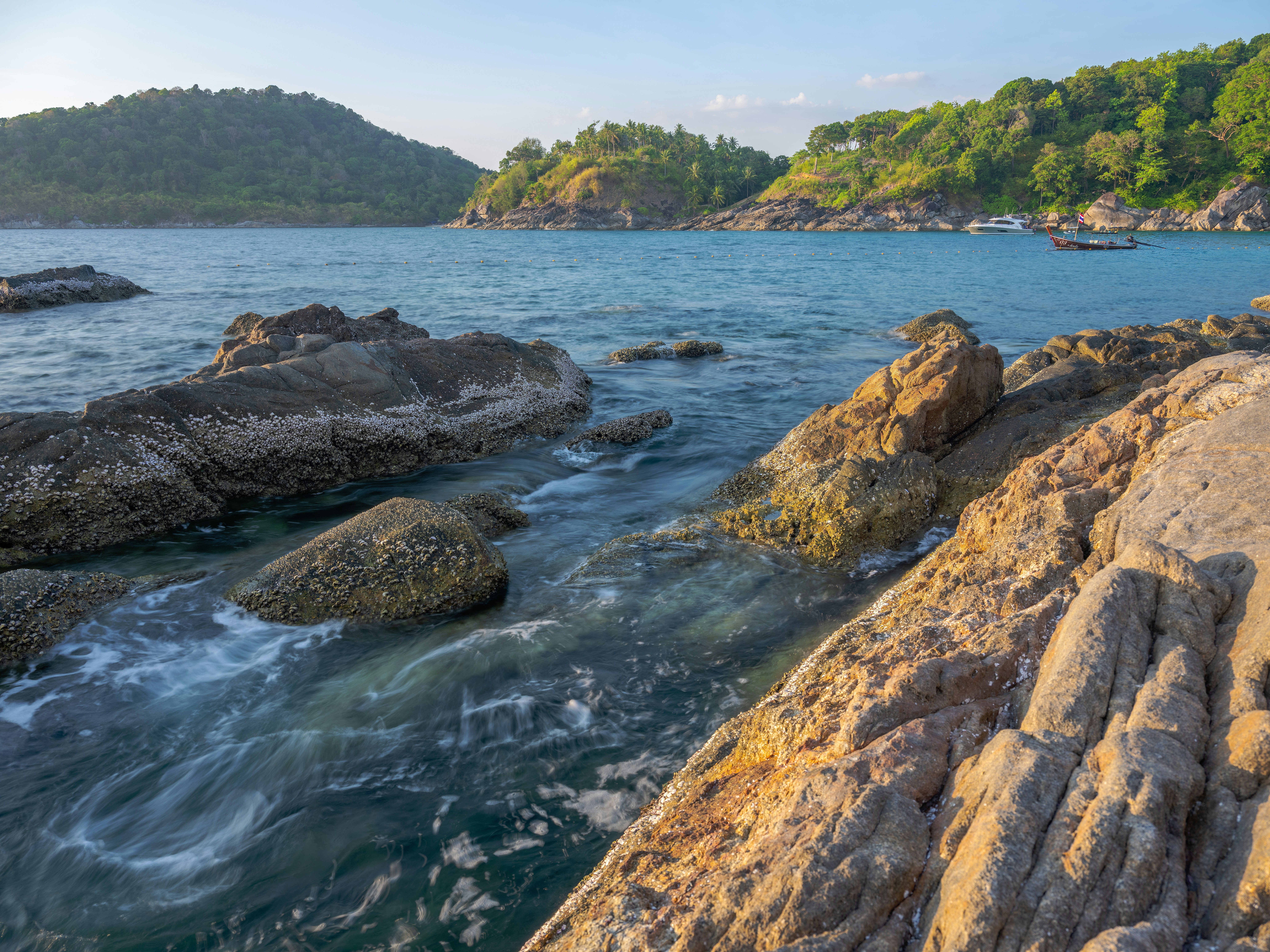 A body of water surrounded by rocks and trees photo – Free Phuket Image ...