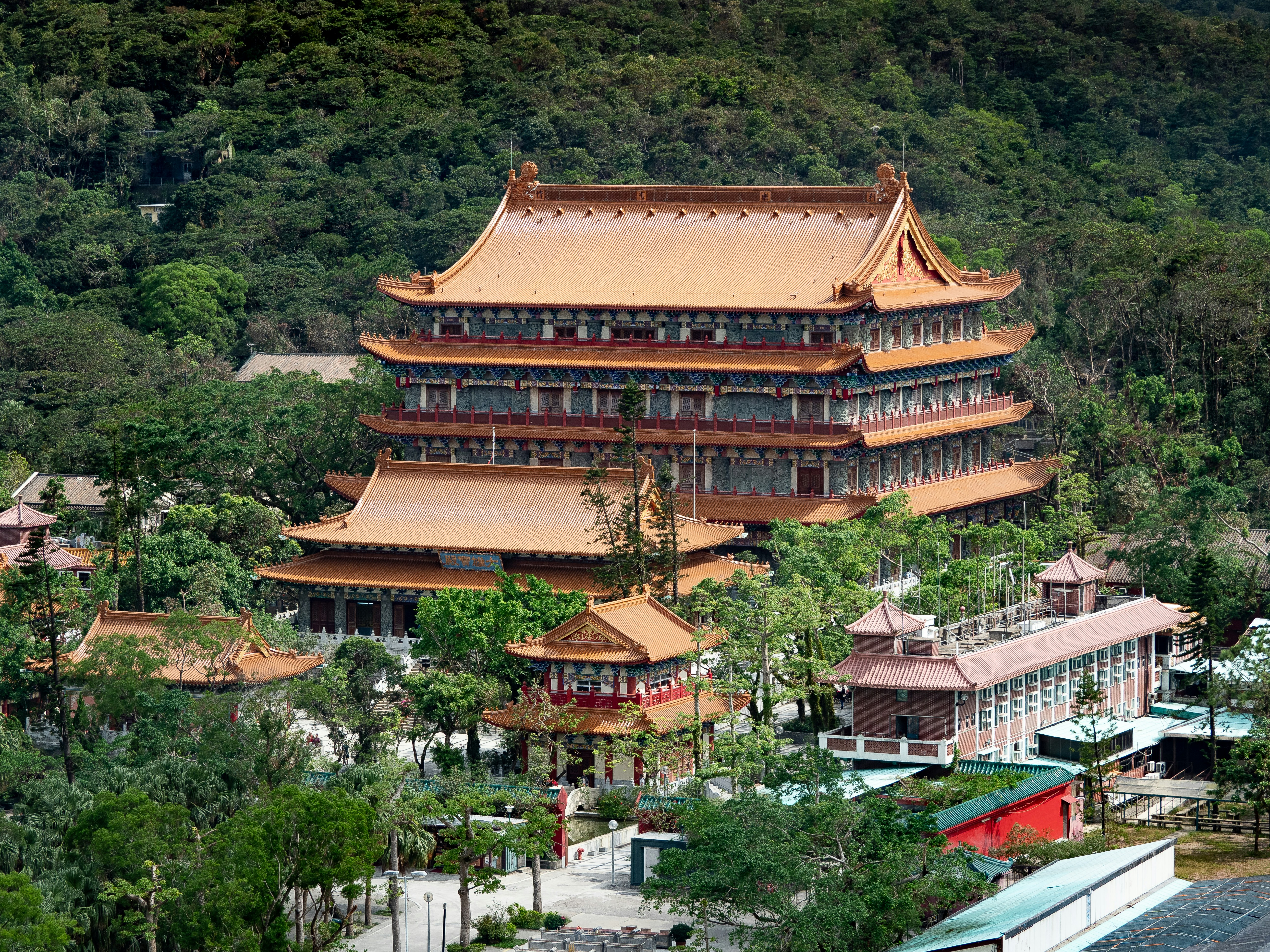 Traditional Chinese architecture of Po Lin Monastery nestled in lush greenery on a hillside.