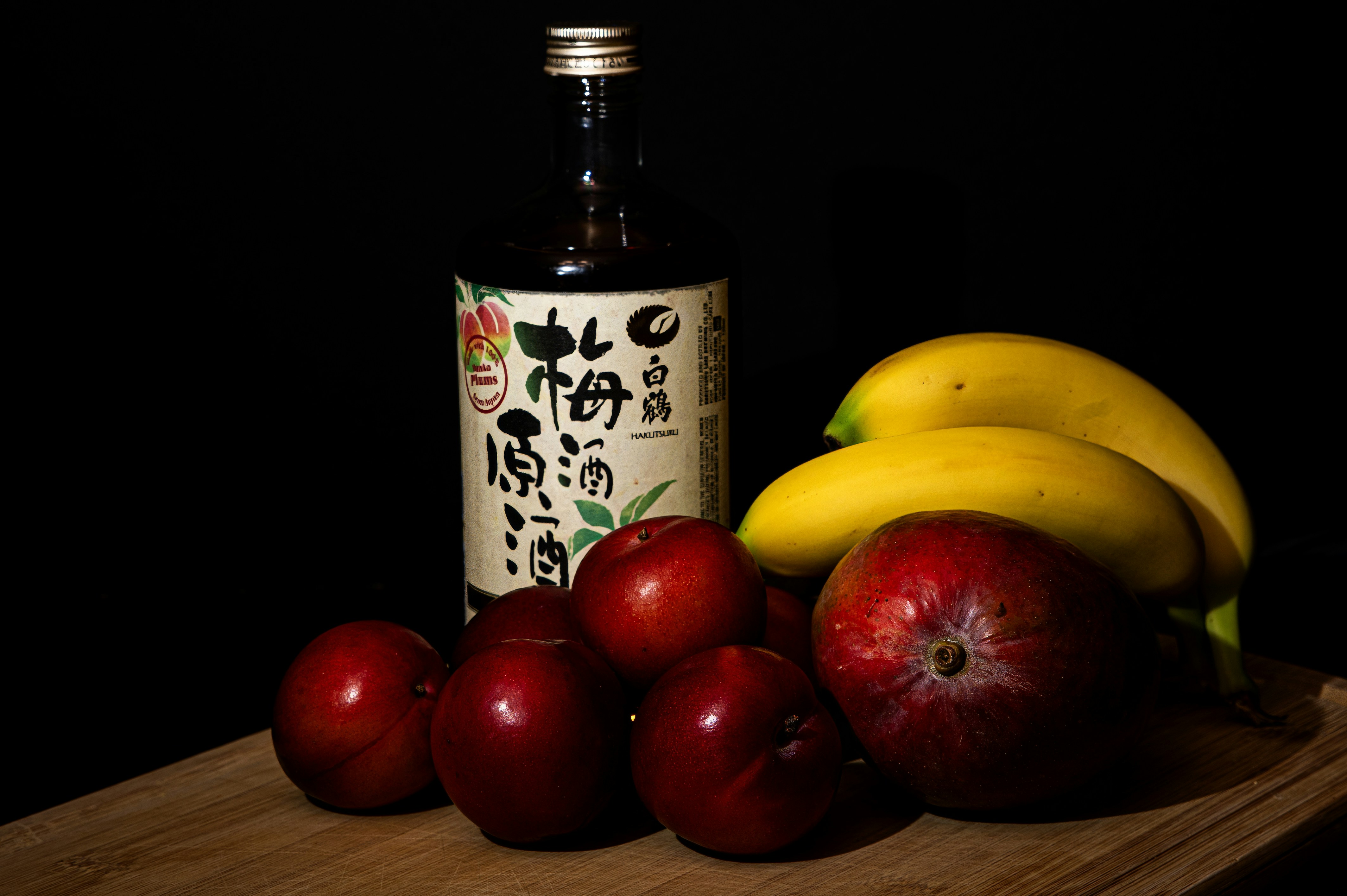 Apples, bananas, and a bottle of sake on a table photo – Free Food ...