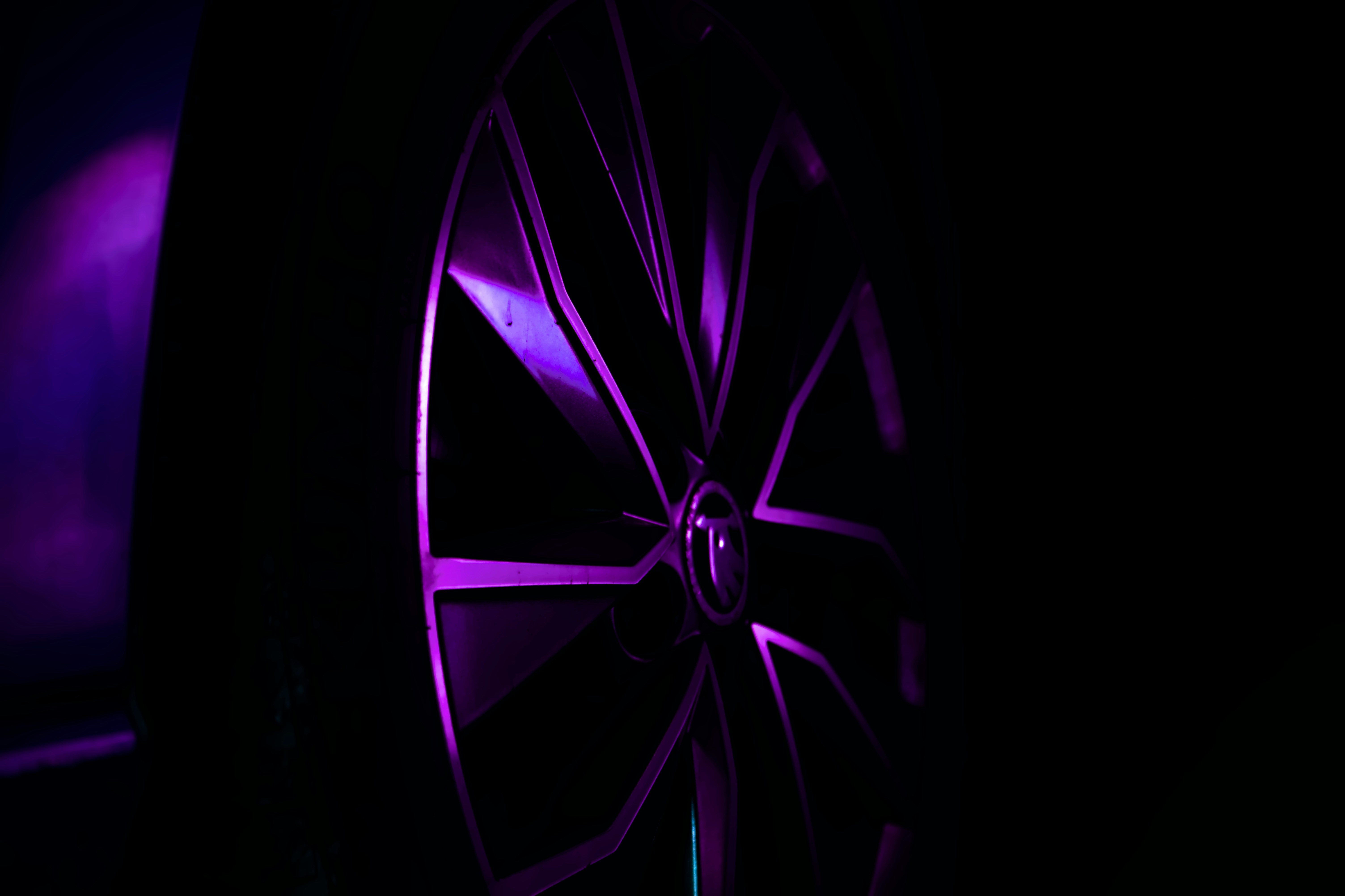 Neon Spokes: A Purple Halo on a Shadowed Wheel