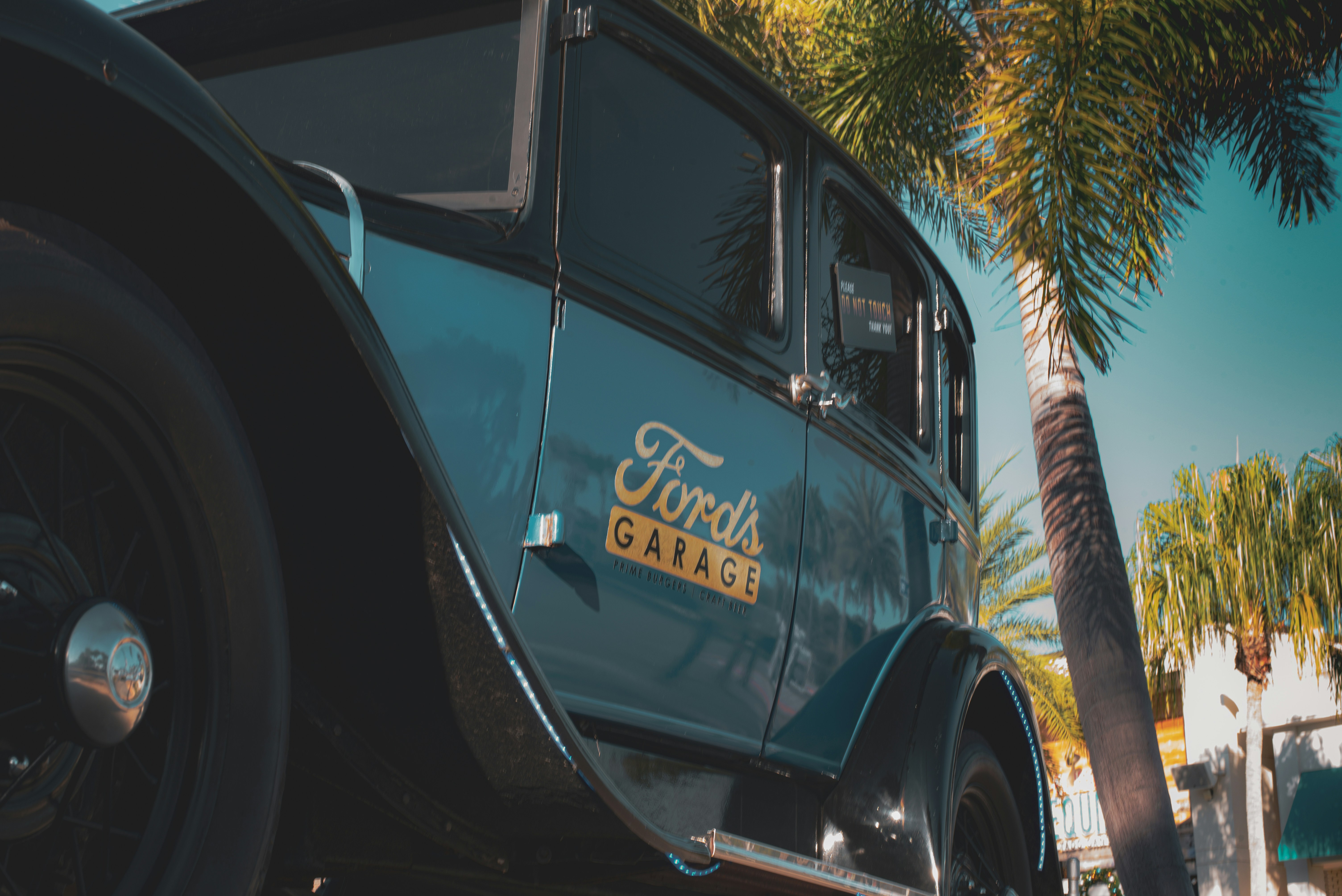 Teal Classic Ford at a Palm-Shaded Boulevard