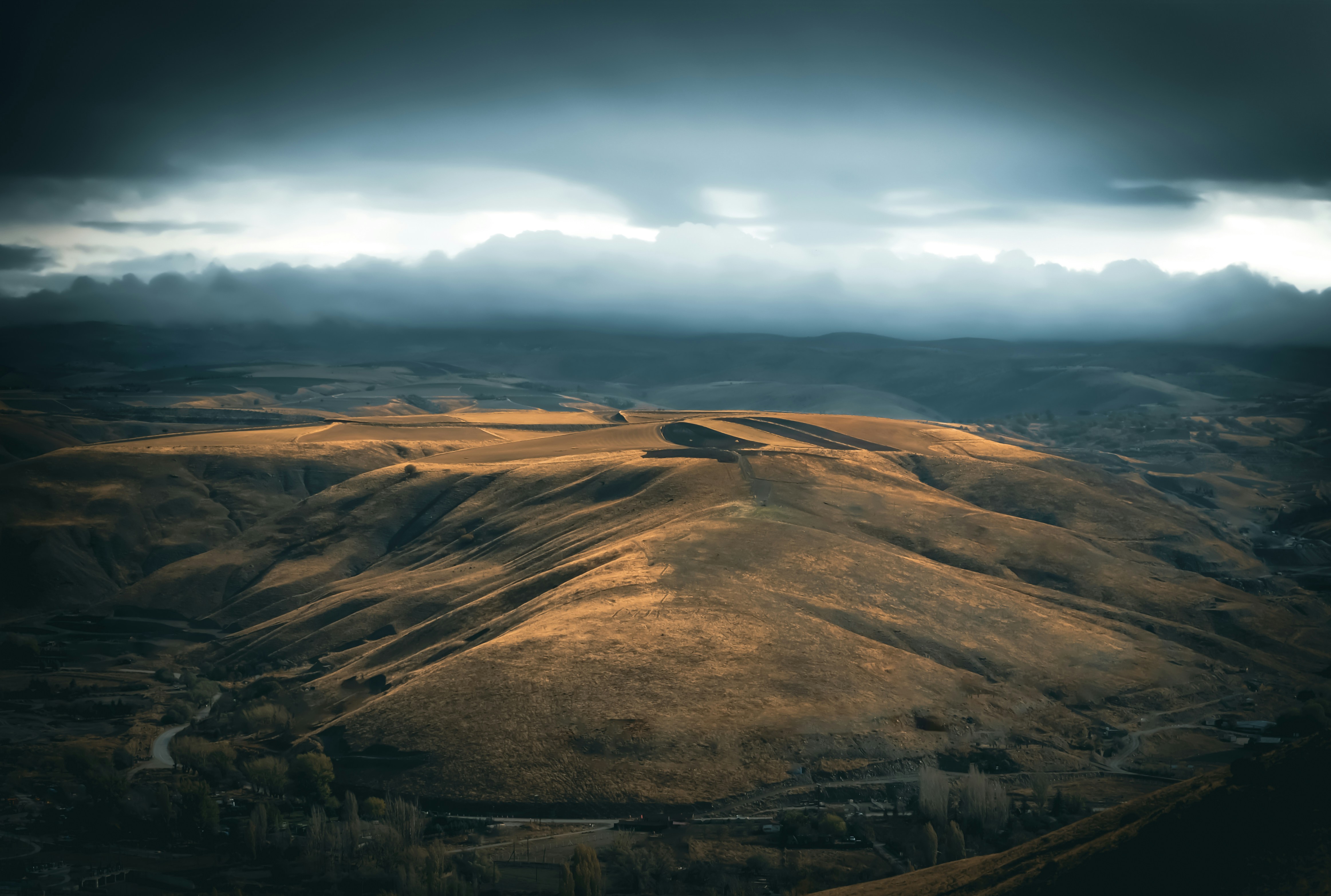 An aerial view of a hilly area under a cloudy sky photo – Free Nature ...