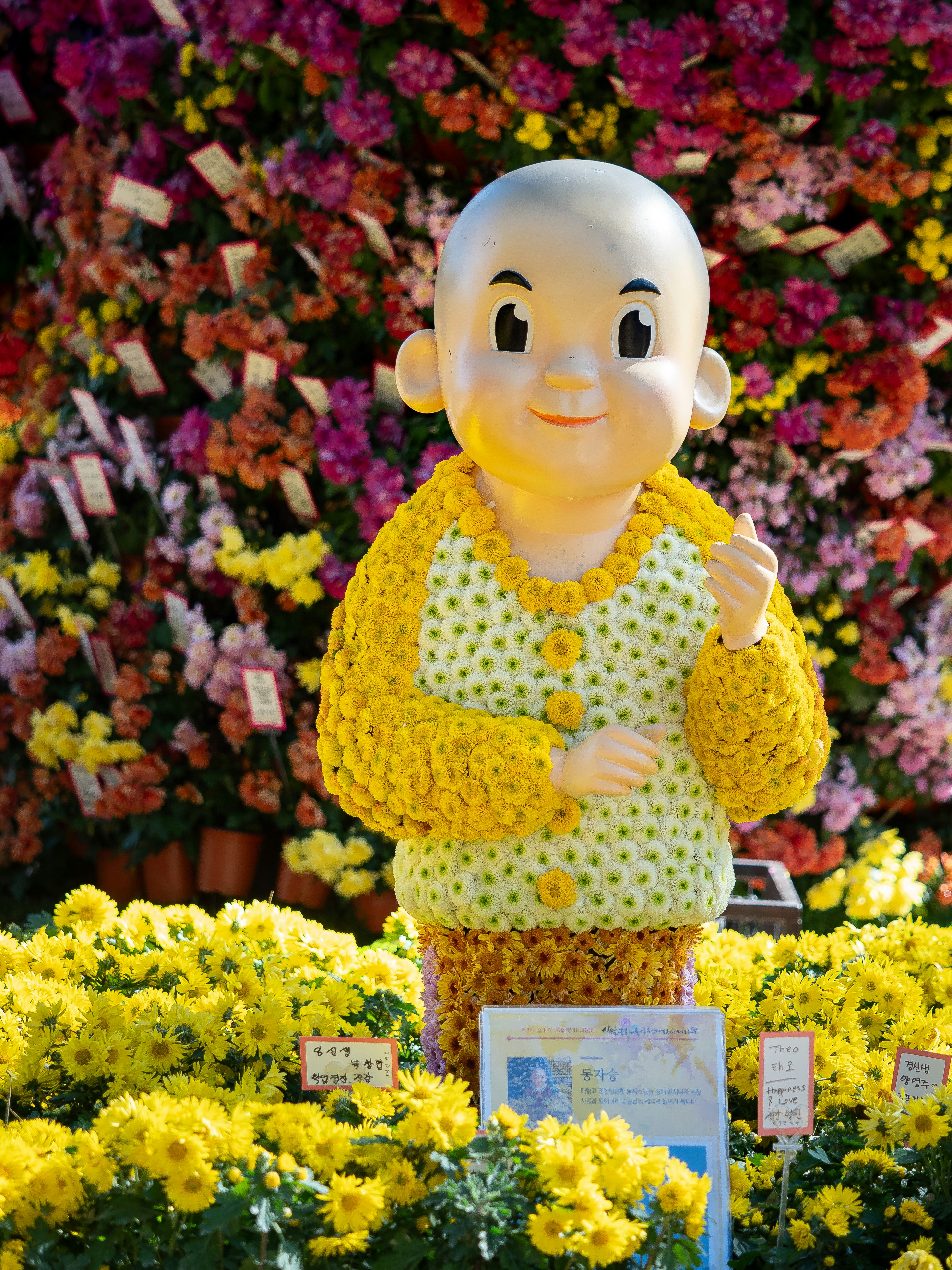 Floral Monk Amid Golden Petals: A Cheerful Sculpture Surrounded by Sunshine