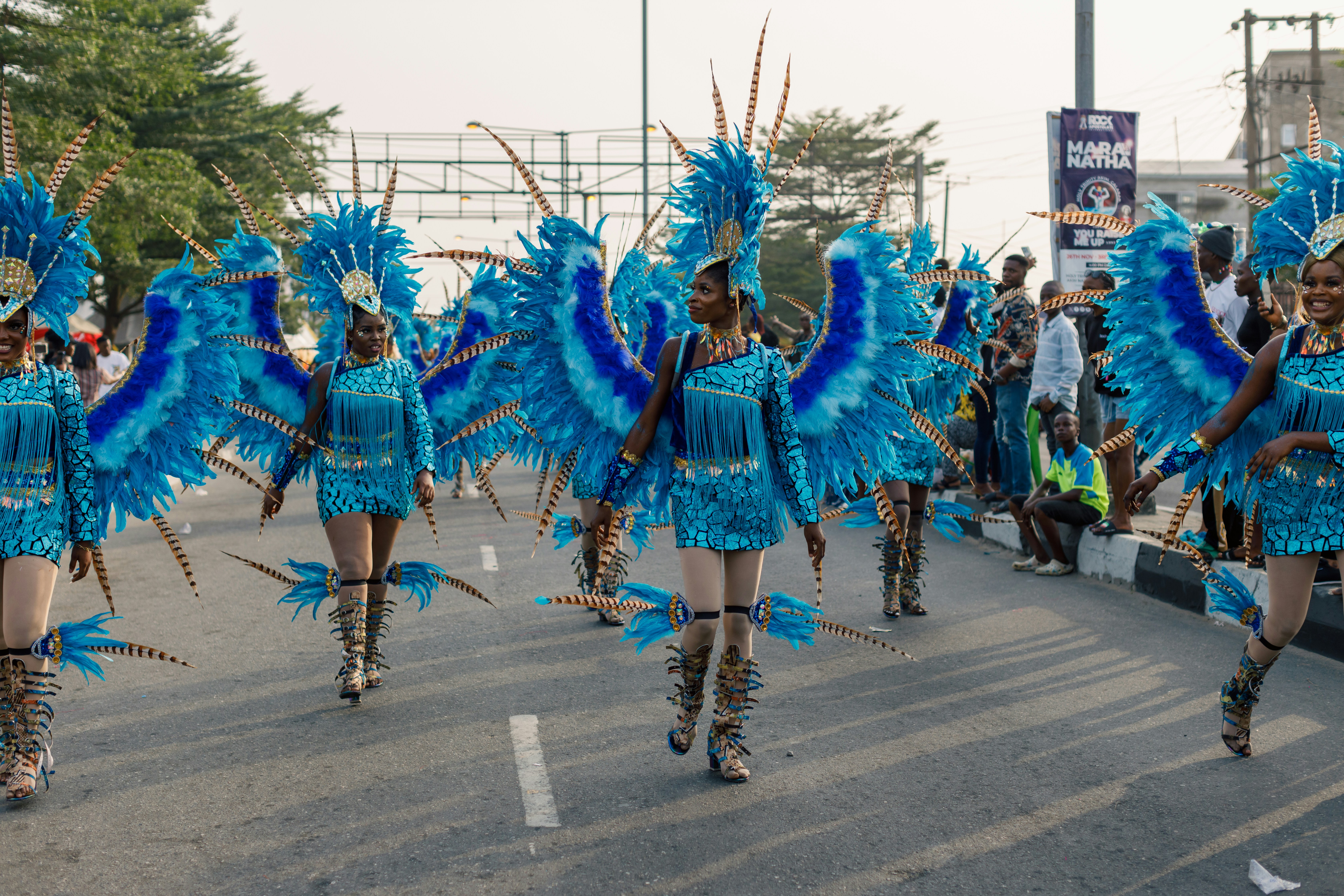 A group of women in blue costumes walking down a street photo – Free ...