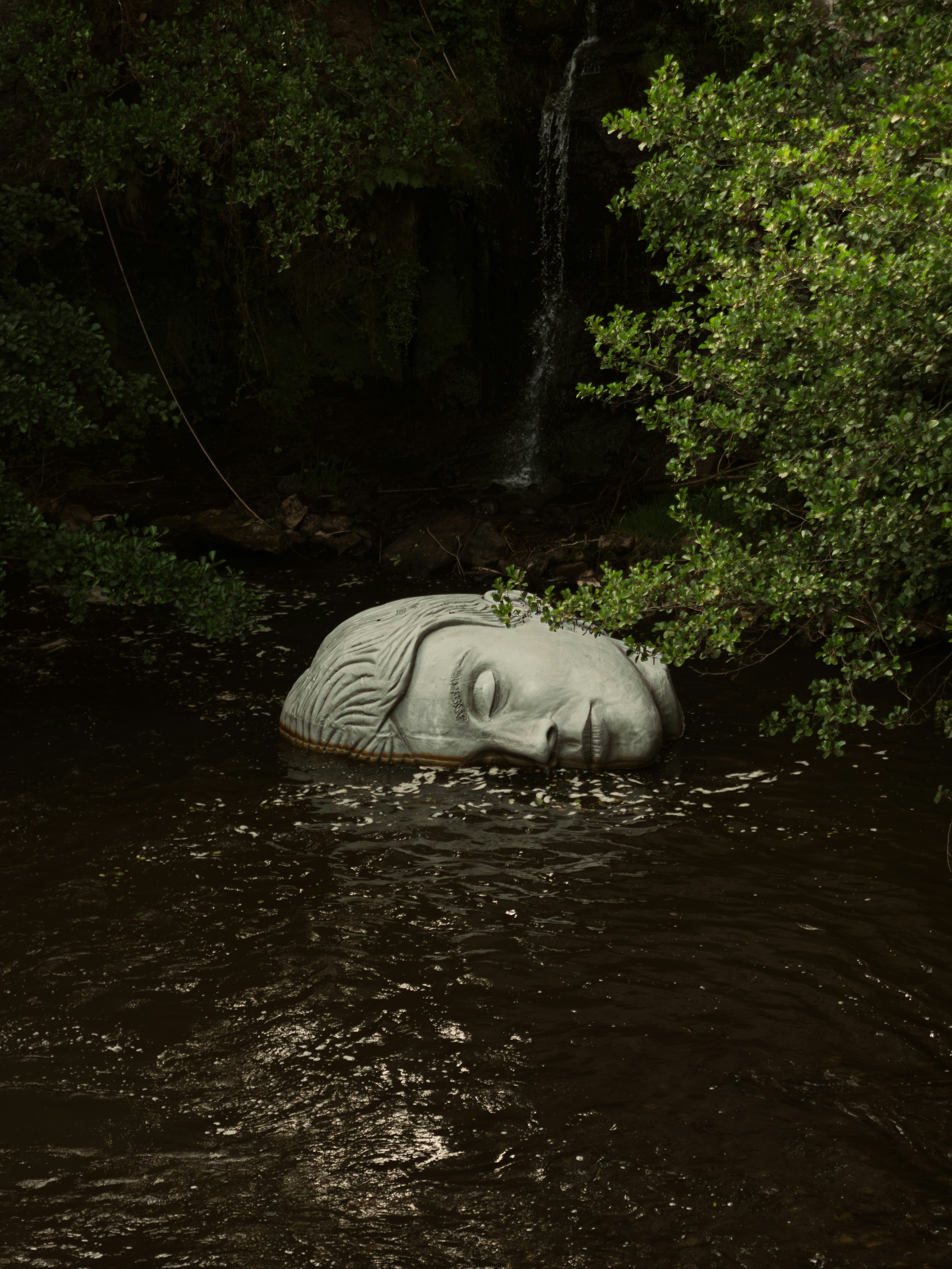 Moonlit Reverie: A Marble Head Drifting Beneath Shadowed Currents