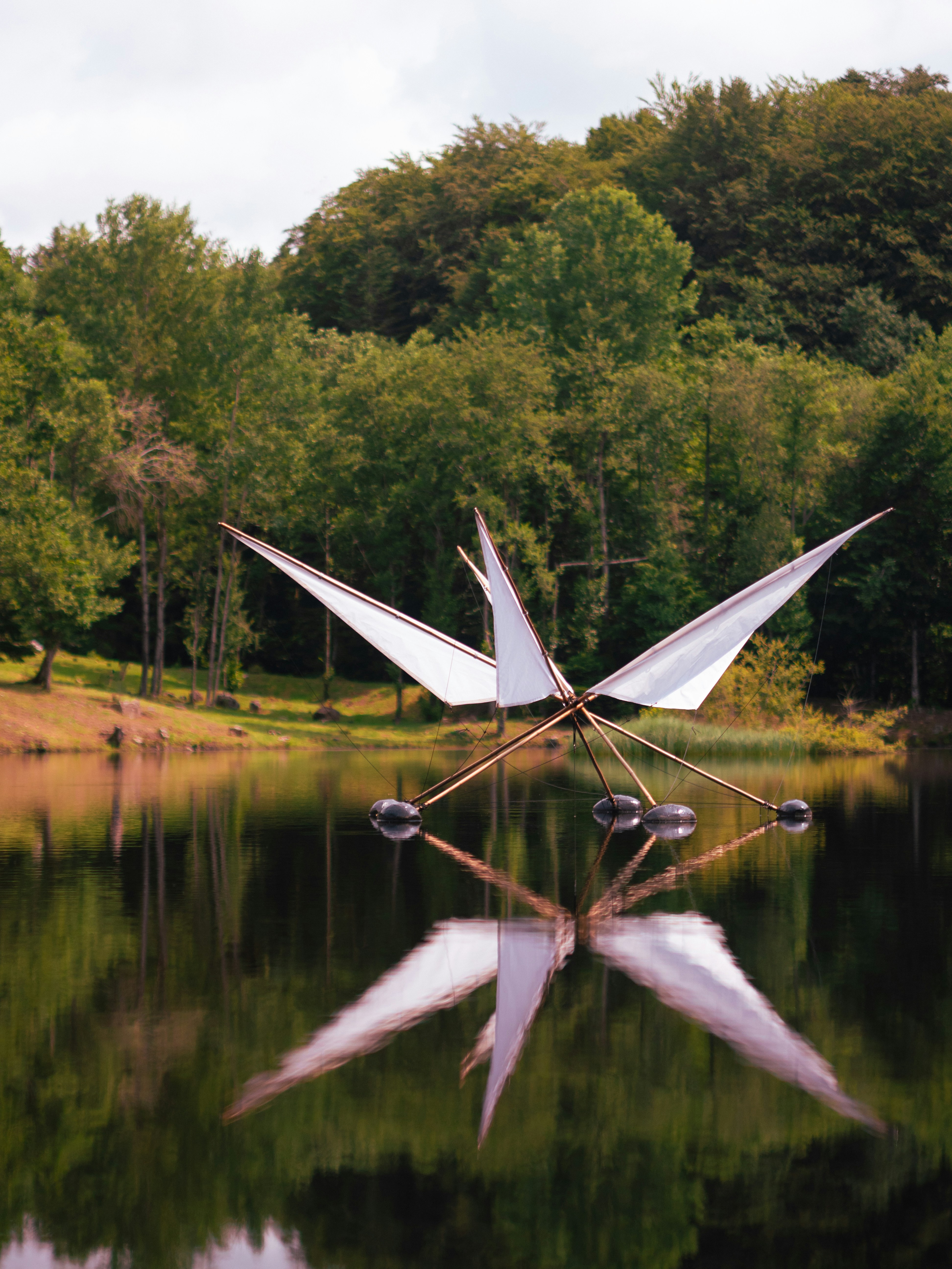 A large white bird sculpture sitting on top of a lake photo – Free ...