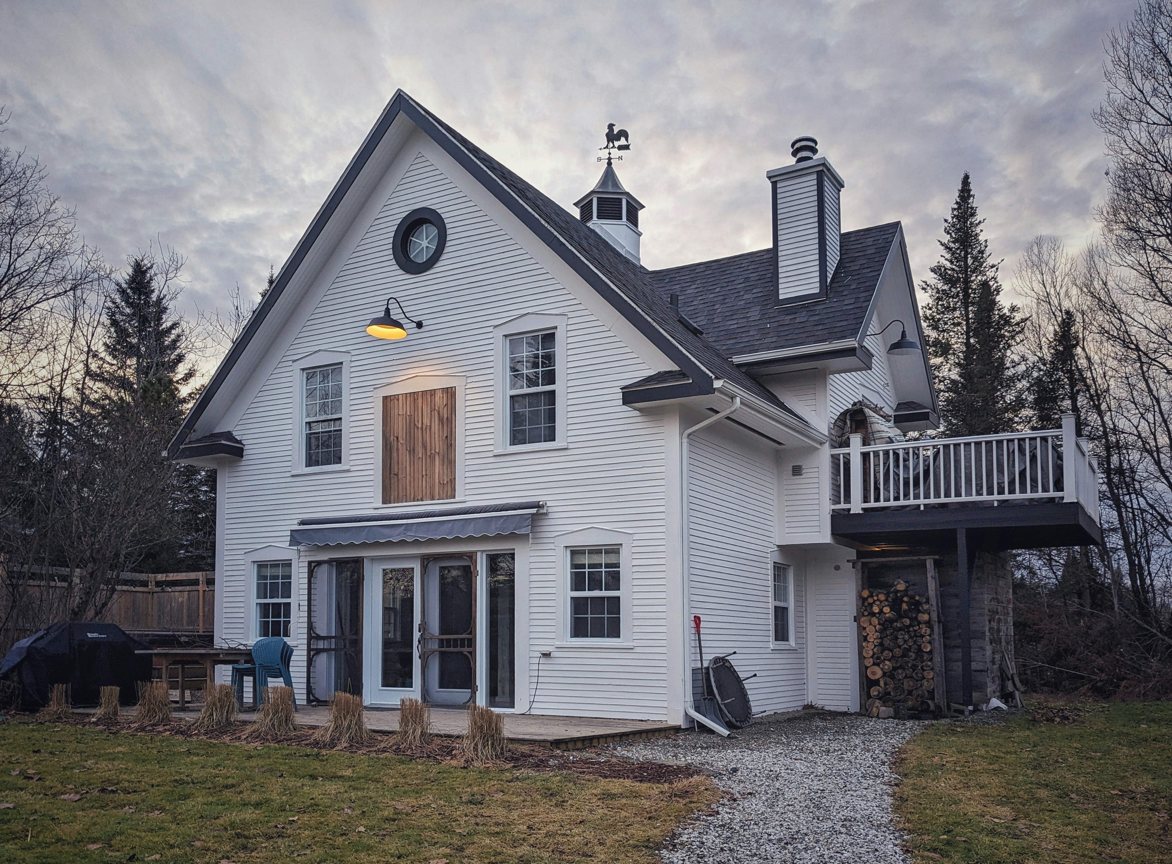 White Farmhouse Quietly Framed by Winter Pines