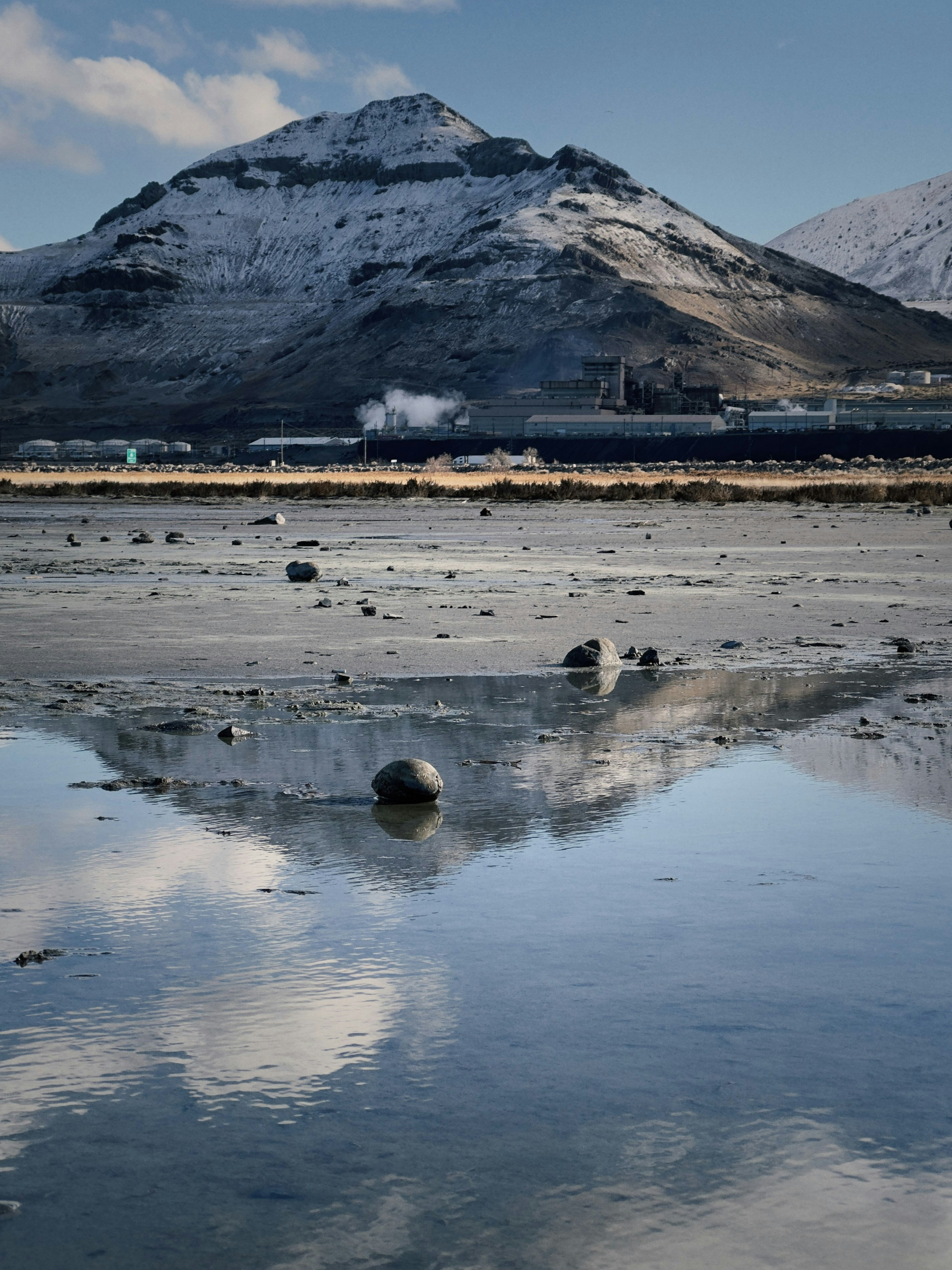 Snow-Capped Peak Framed by Coastal Flat and Reflections