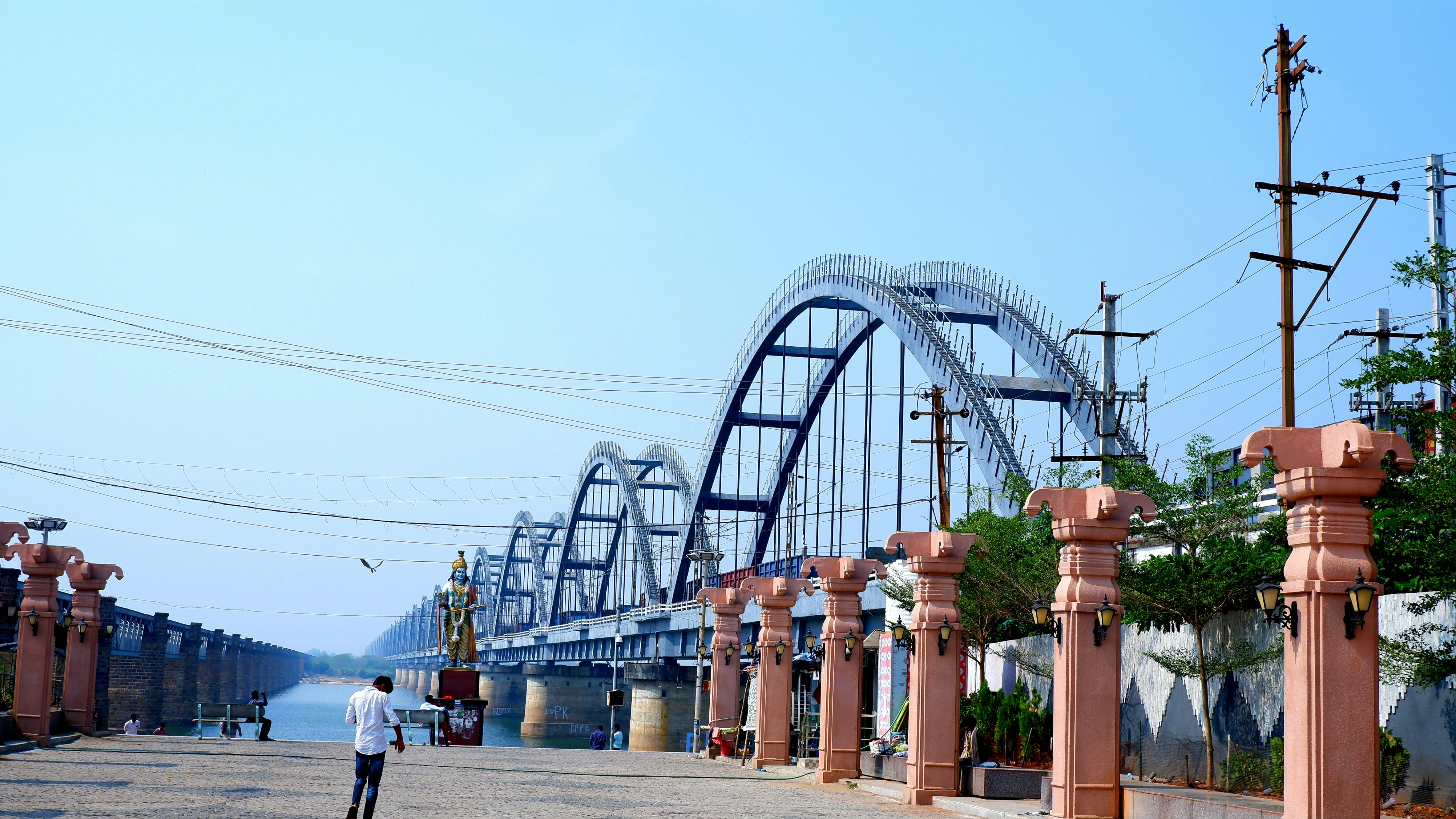 A man walking down a street next to a bridge photo – Free Pushkar ghat ...