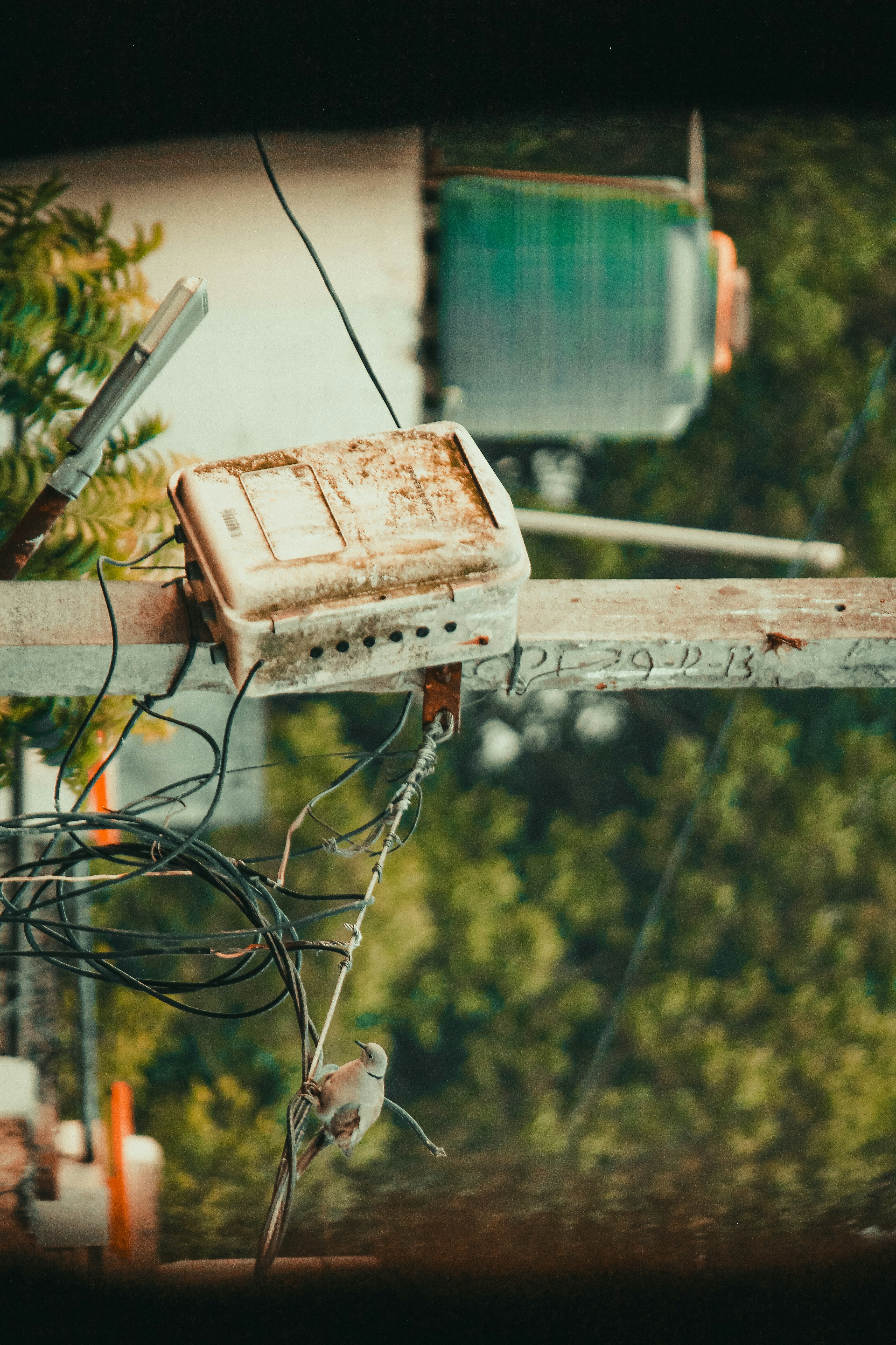 Rusted Utility Box and Tangle of Wires on a Weathered Balcony Rail