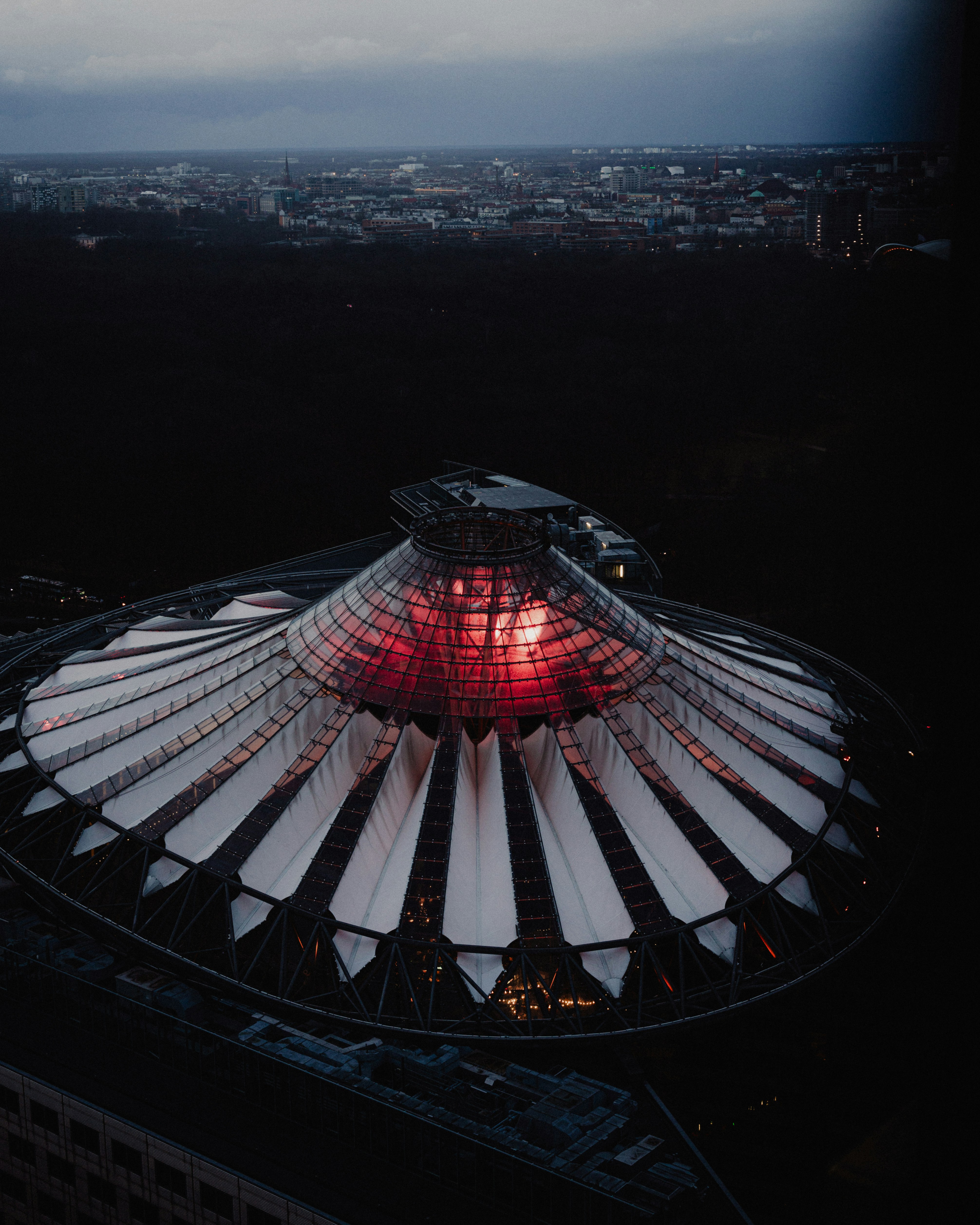 Iron Ring Under Neon Sky: Aerial View of the Ringed Pavilion at Dusk
