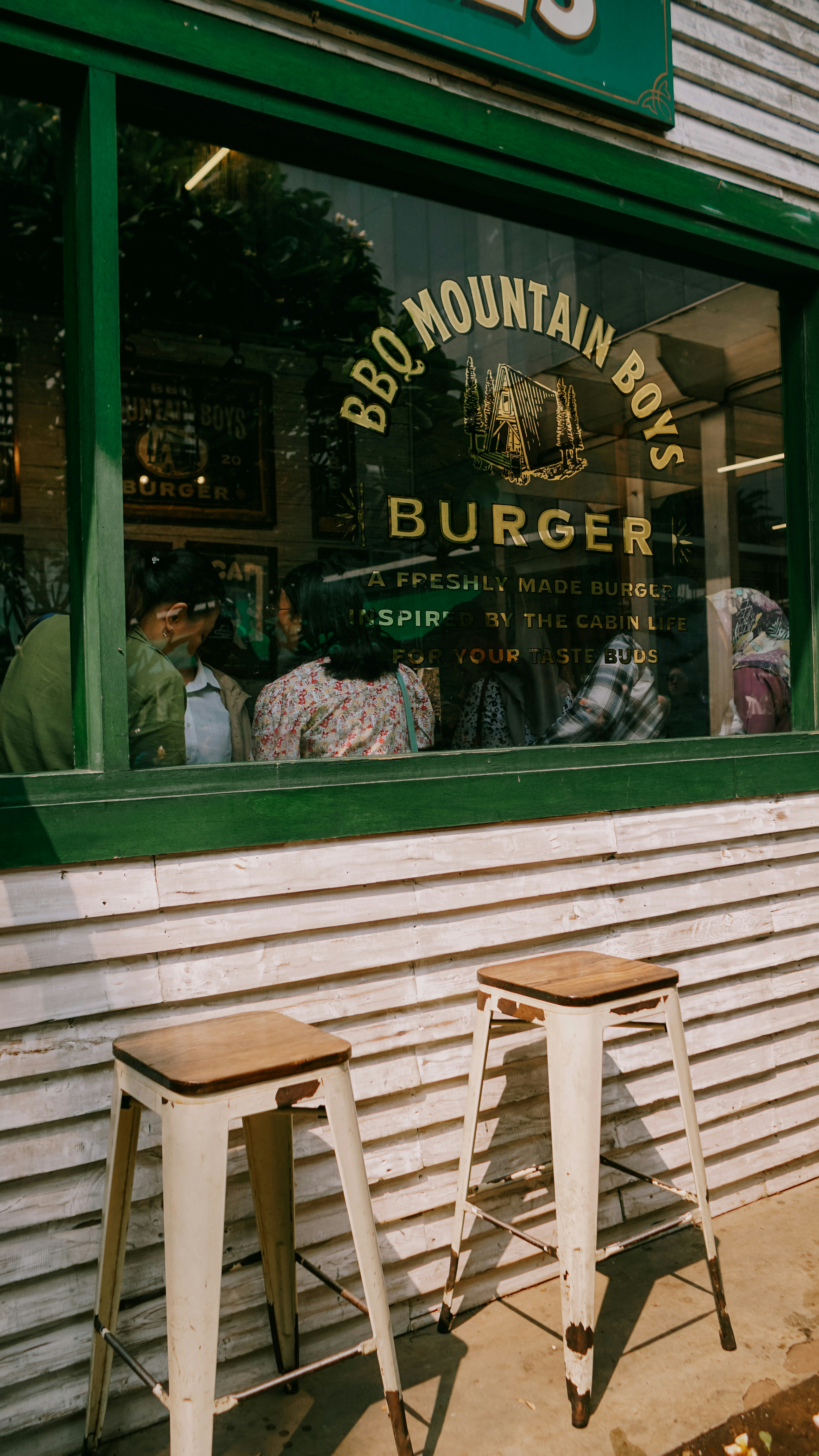 Two wooden stools sitting outside of a restaurant photo – Free Burger ...