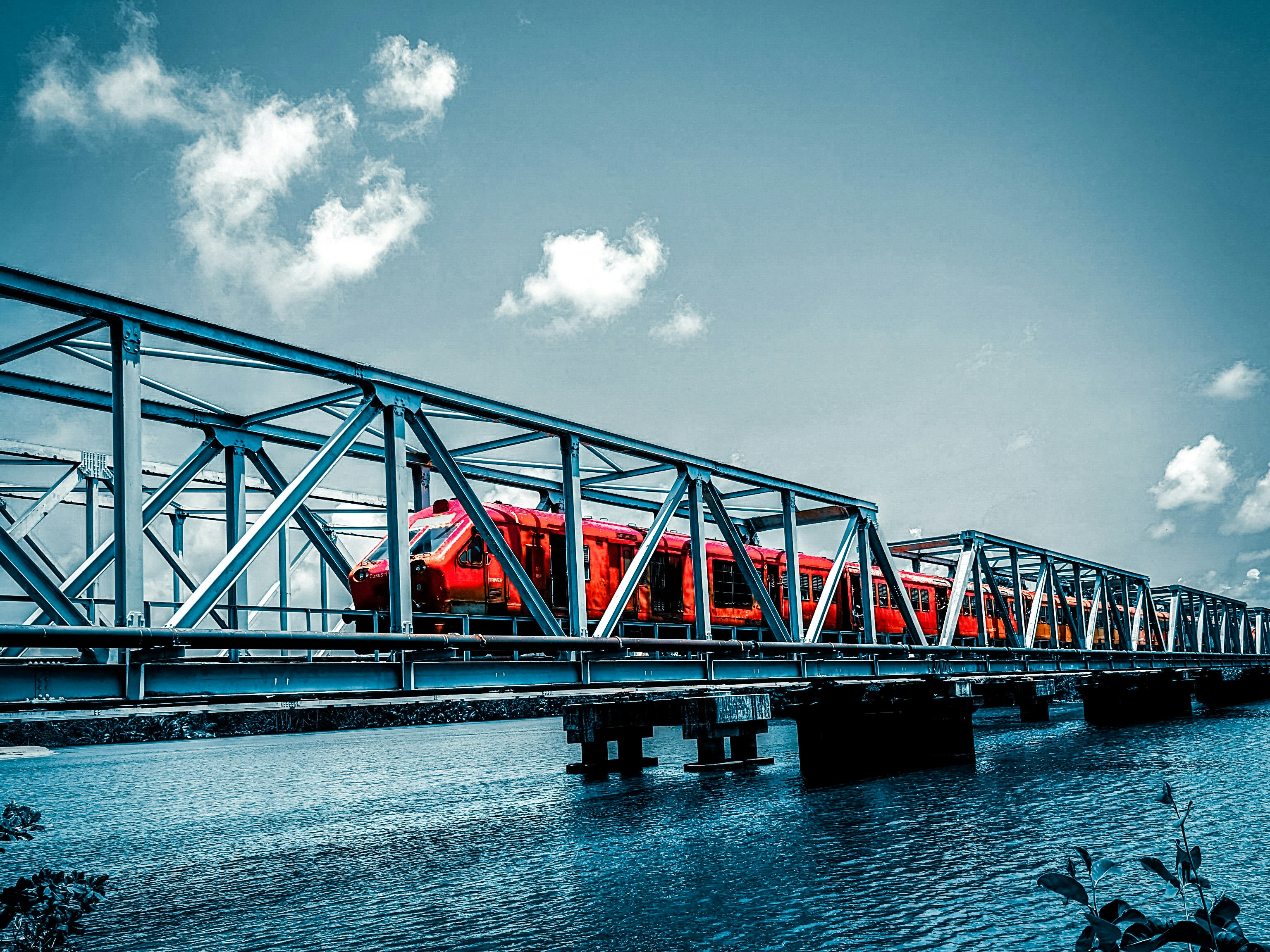 A red train traveling across a bridge over water photo – Free Wallpaper ...