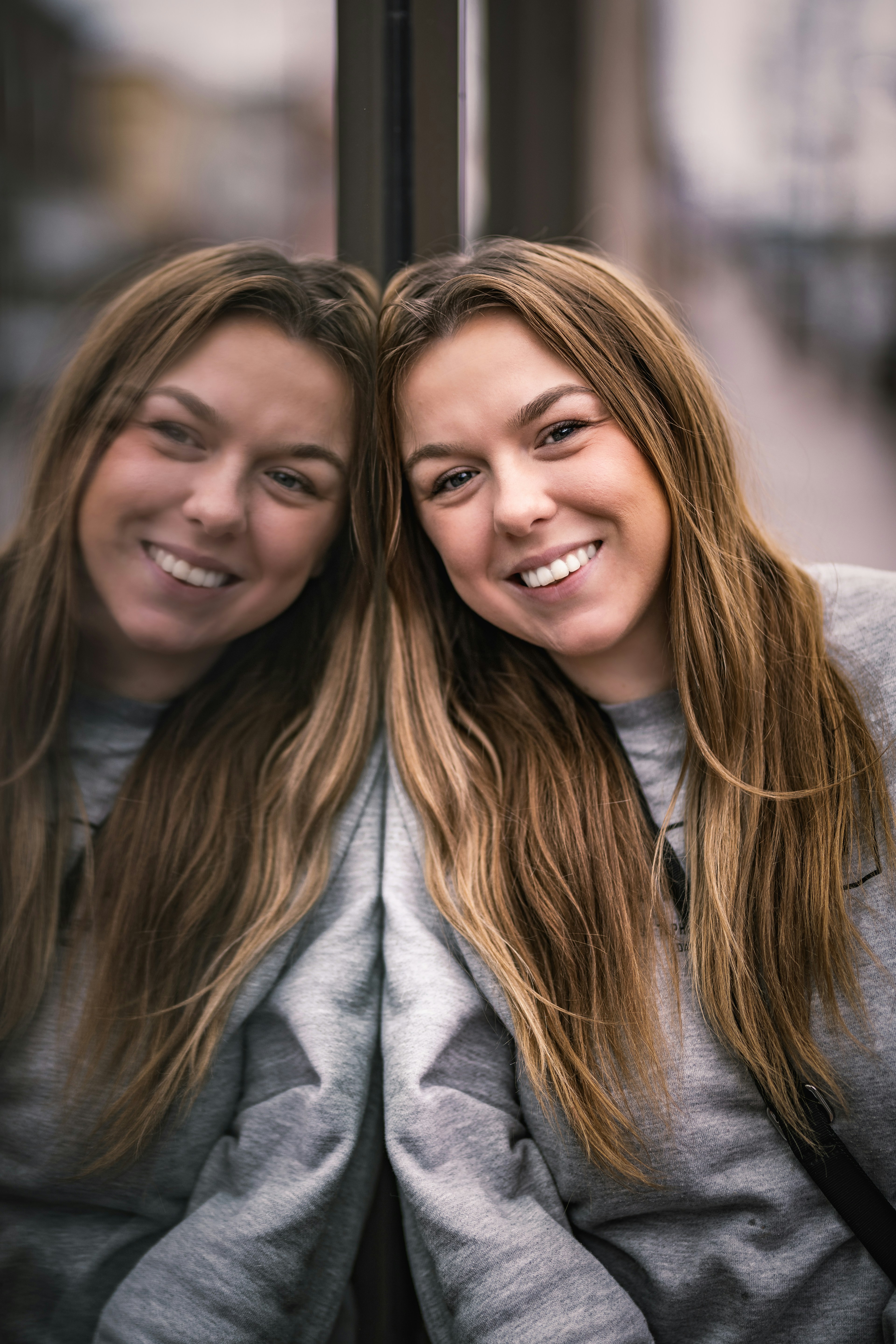 Two young women sitting next to each other near a window photo – Free ...