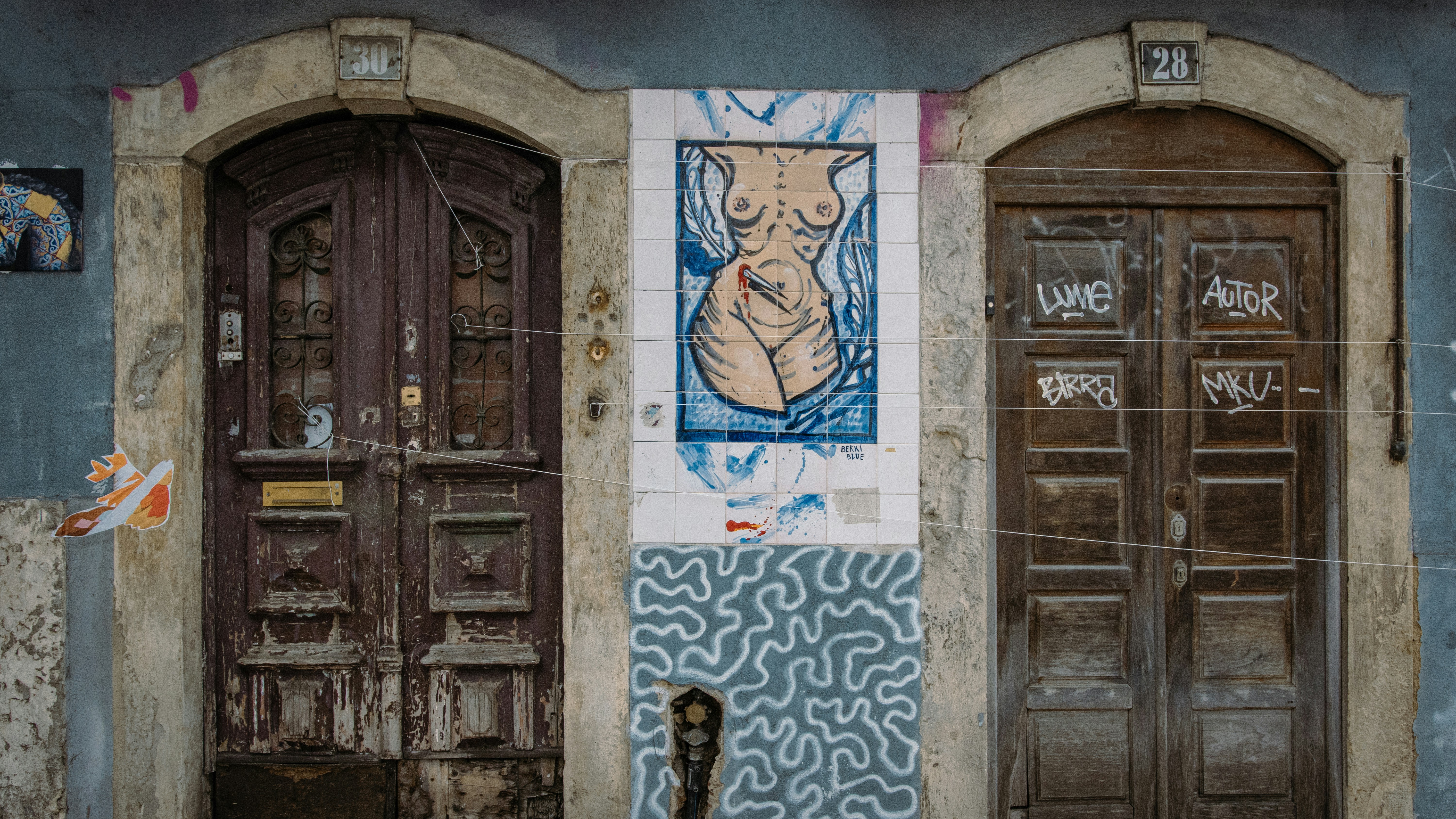 a building with two doors and graffiti on it