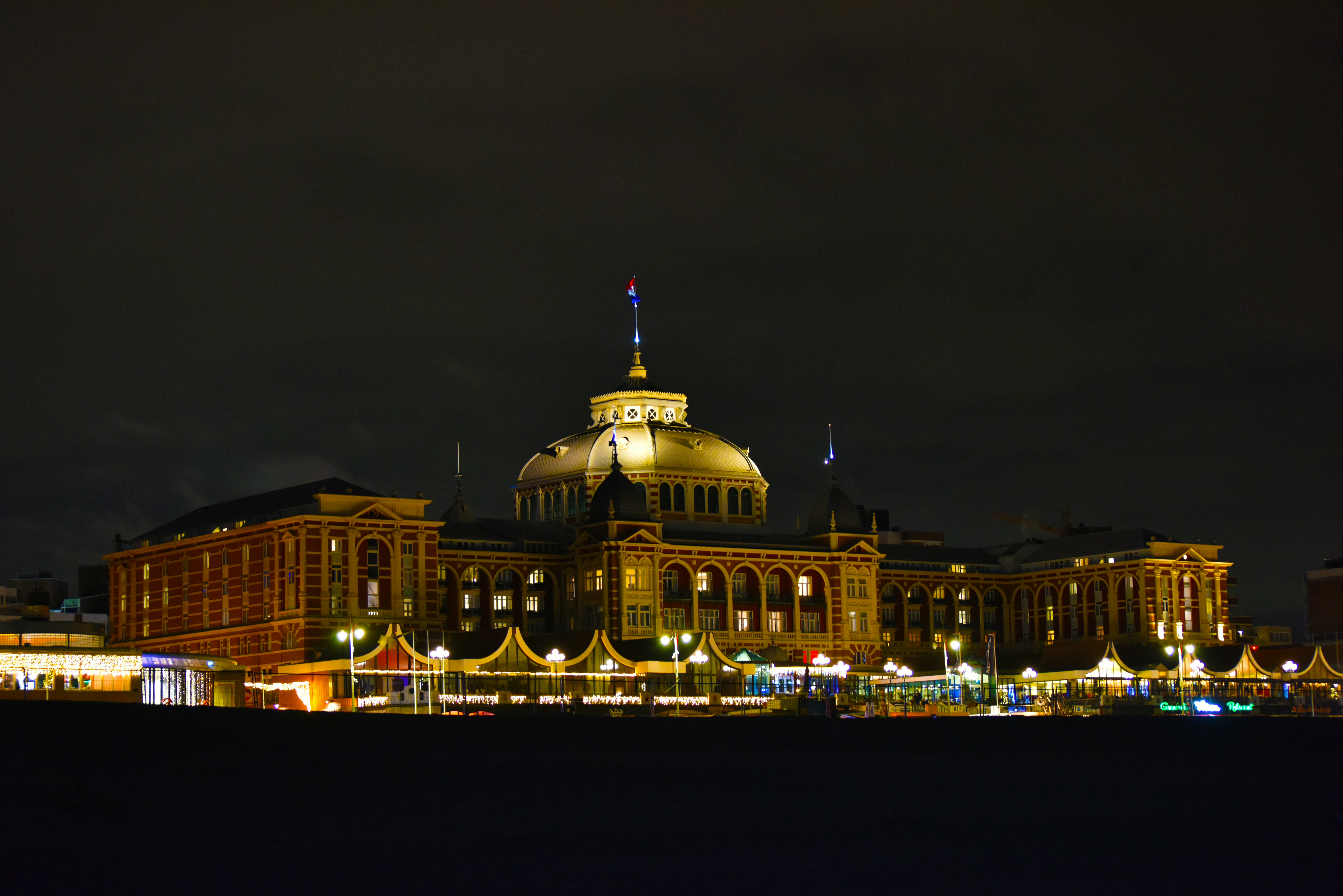 Historic Kurhaus building glowing with lights against a dark night sky.