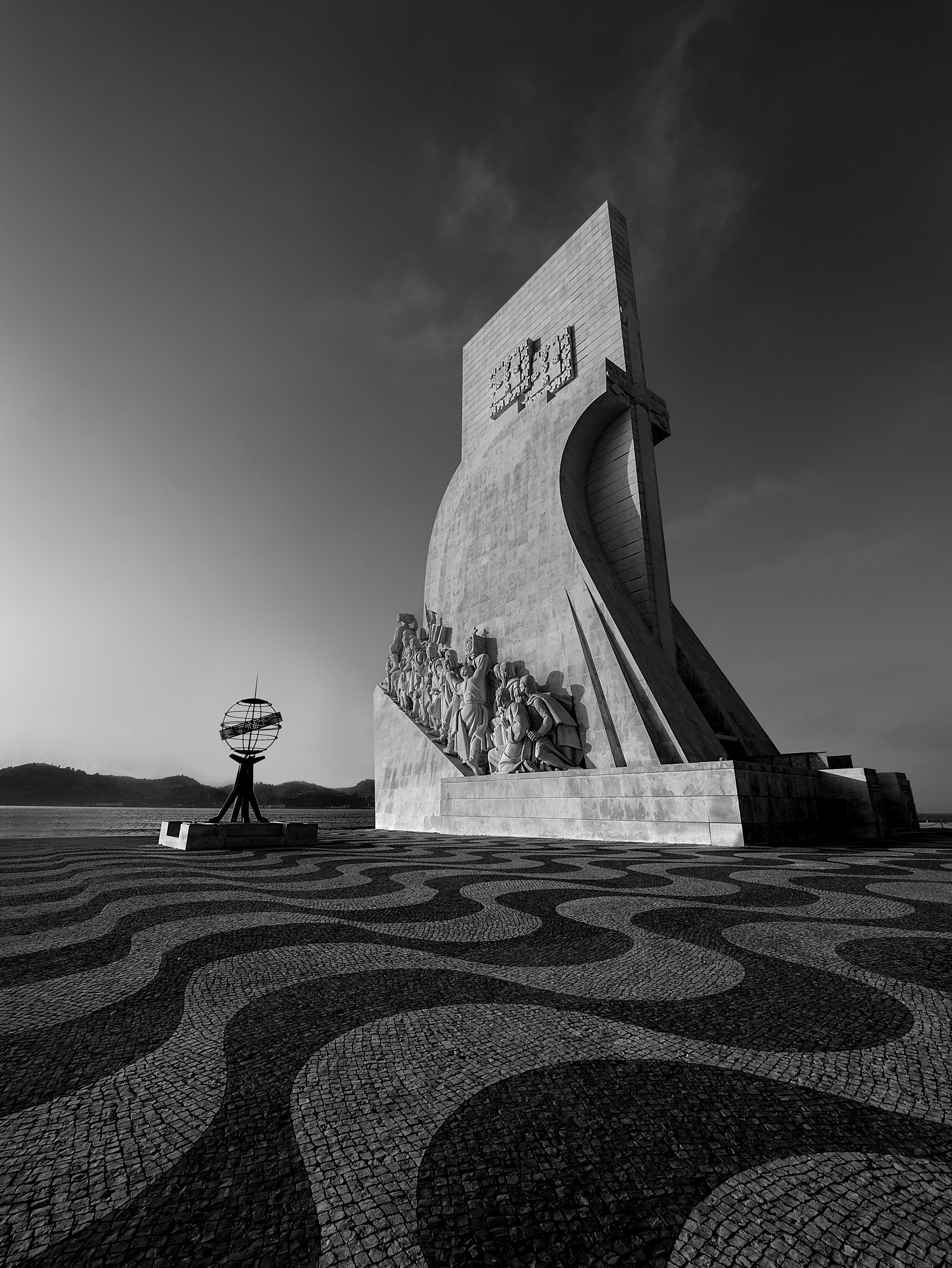 Arc of Stone: Reliefs Rising Over a Sea-Patterned Plaza
