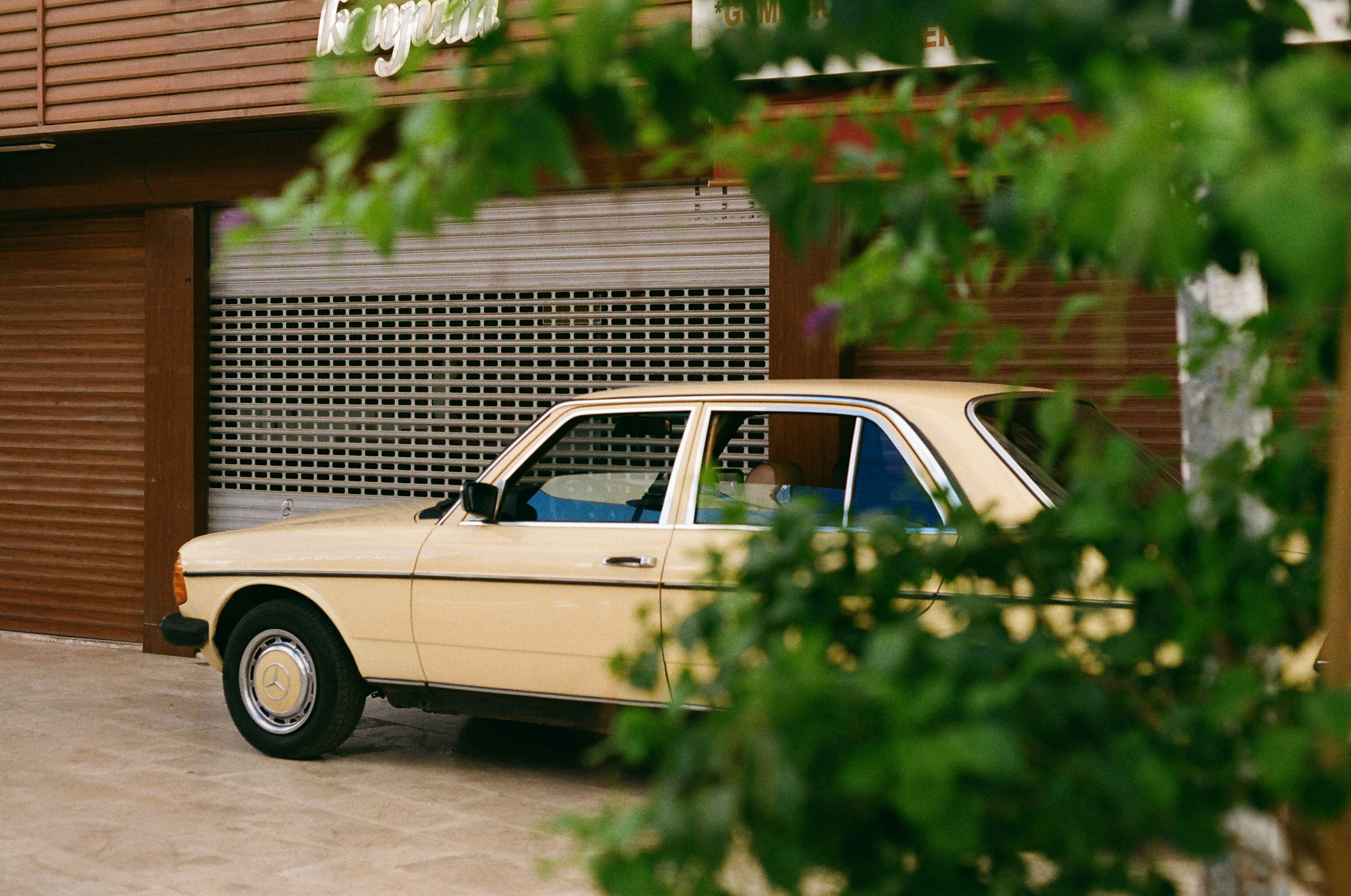 An old Mercedes behind lush green plants in the old town of Antalya.
