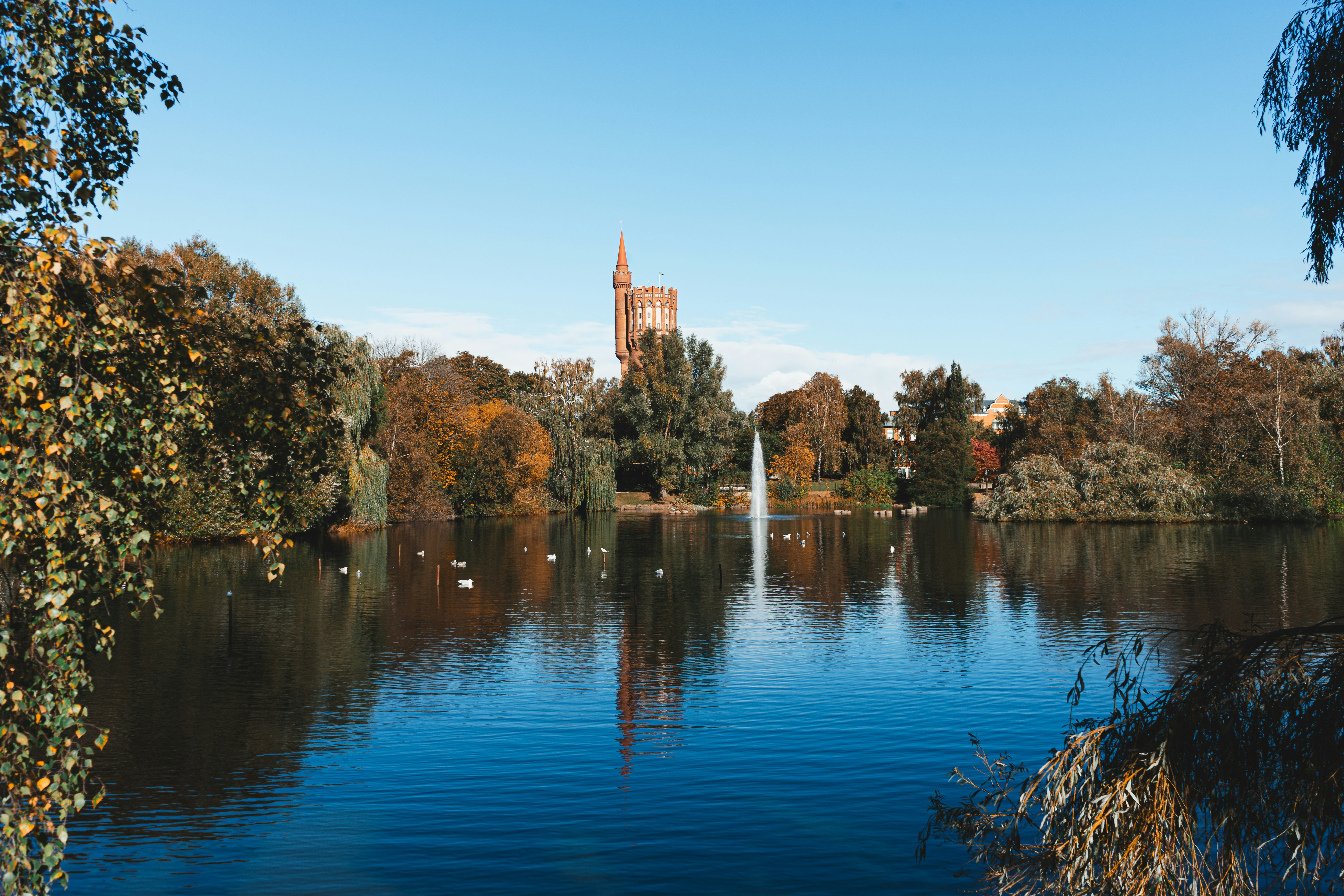 Autumn Turret Over a Tranquil Lake: Reflections and a Central Fountain