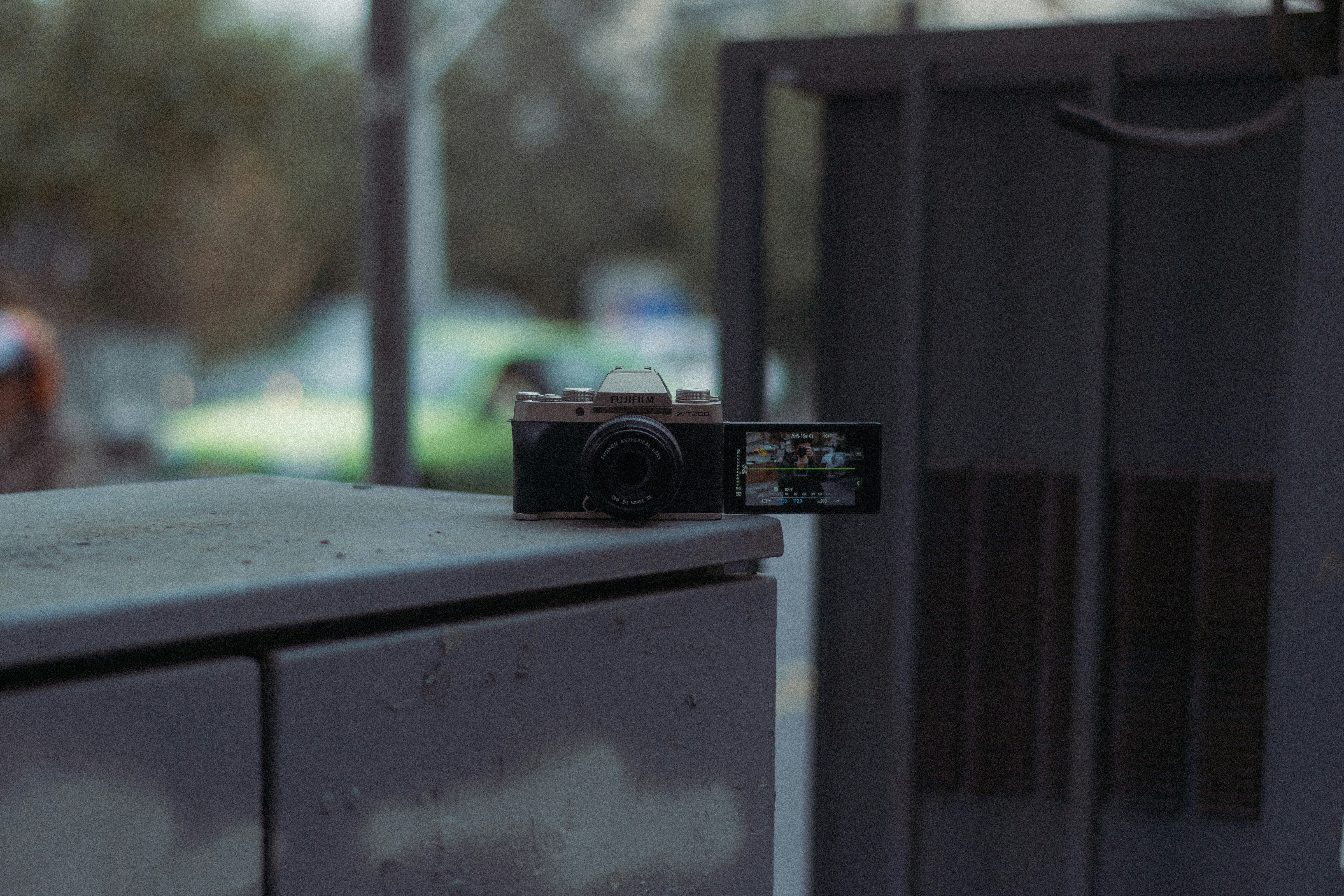 Edge of Focus: a DSLR perched on a weathered ledge with a flickering urban backdrop
