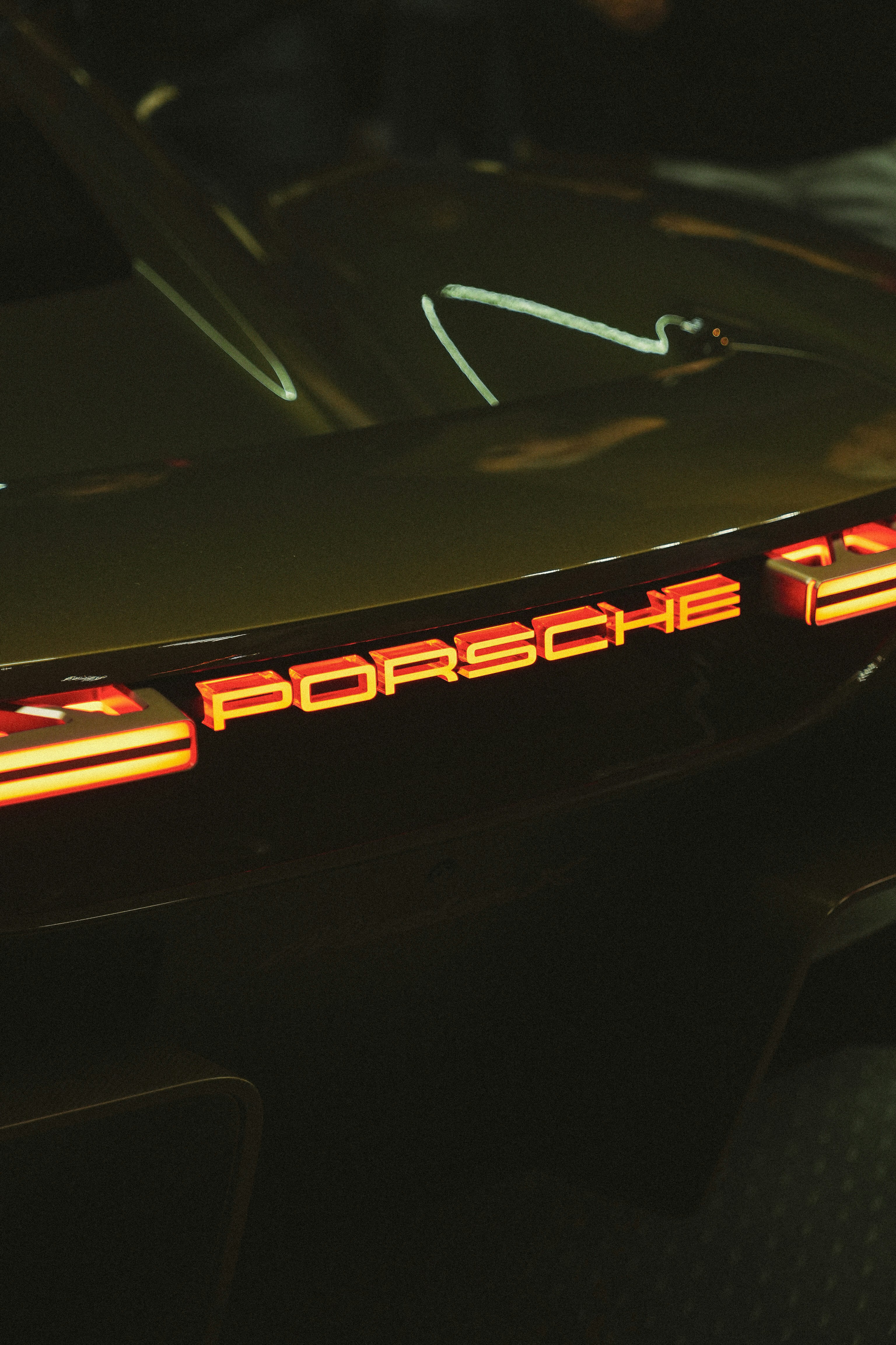 Crimson Porsche Script Illuminates a Shadowed Rear Panel