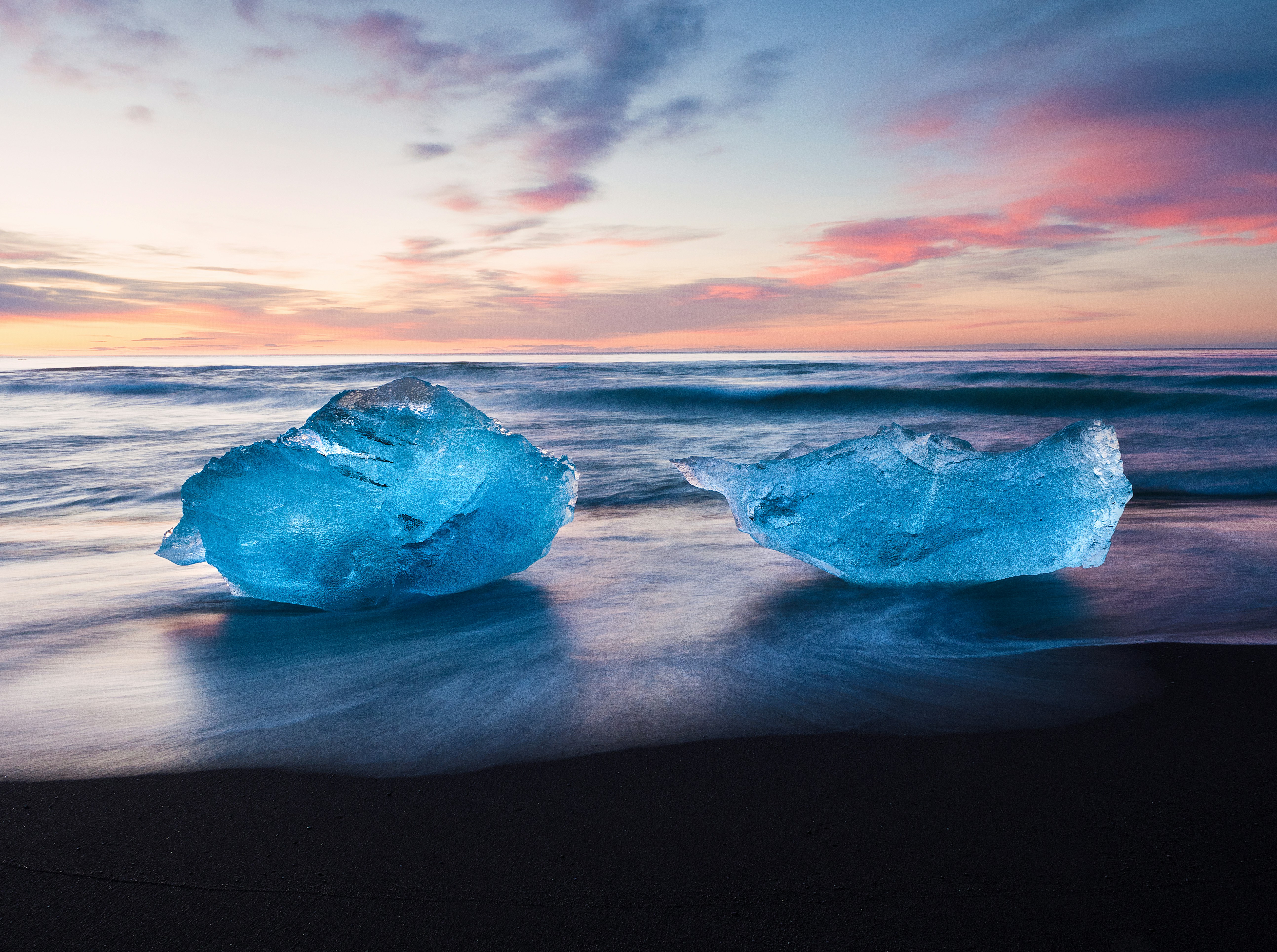 Glacial Echoes: Icebergs Resting on a Velvet Sunset Beach