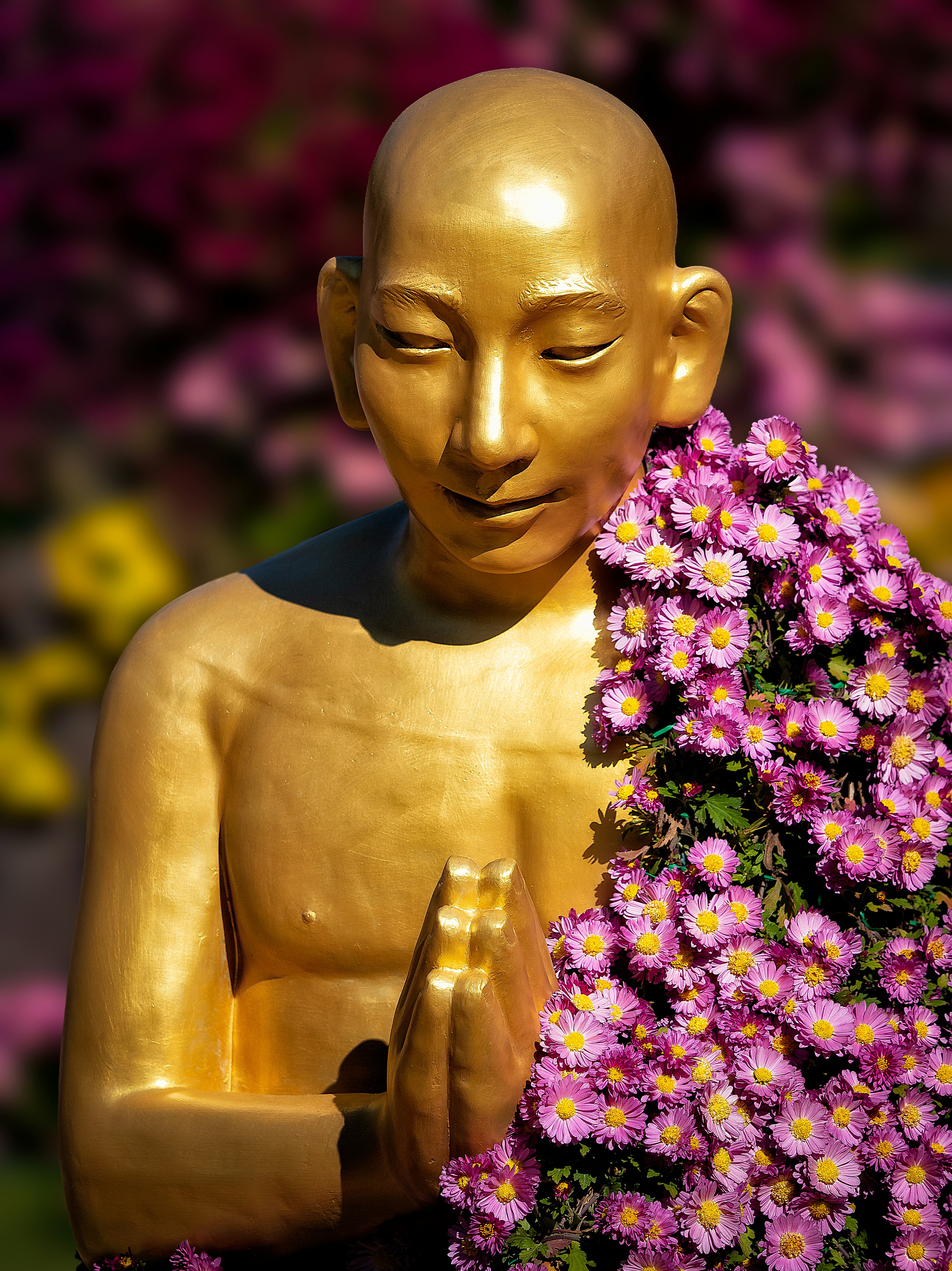 Gilded Serenity: A Golden Monk Framed by Purple Blossoms