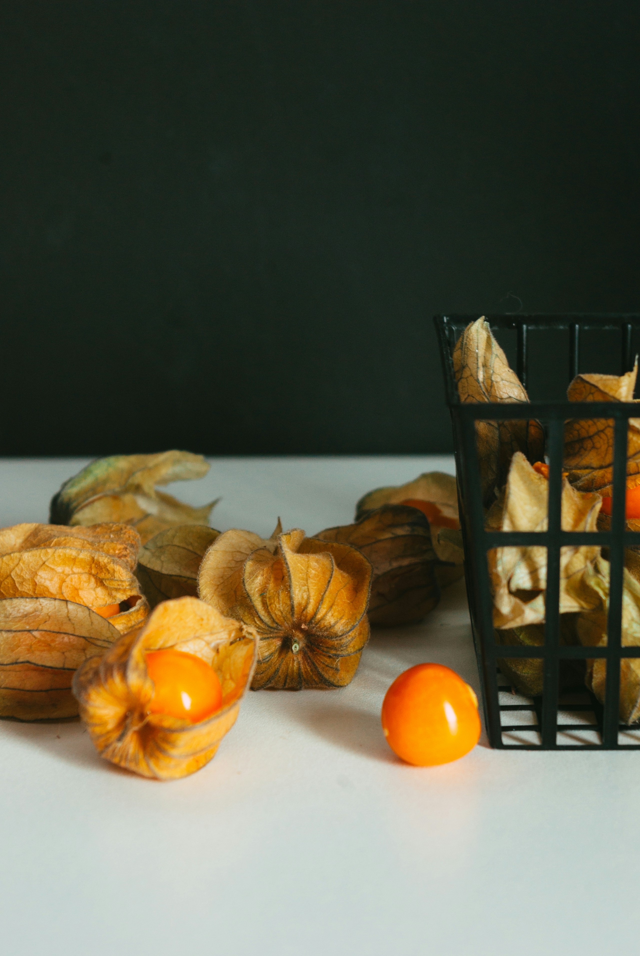 Physalis Lanterns on White: A Quiet Still-Life with a Grid Basket