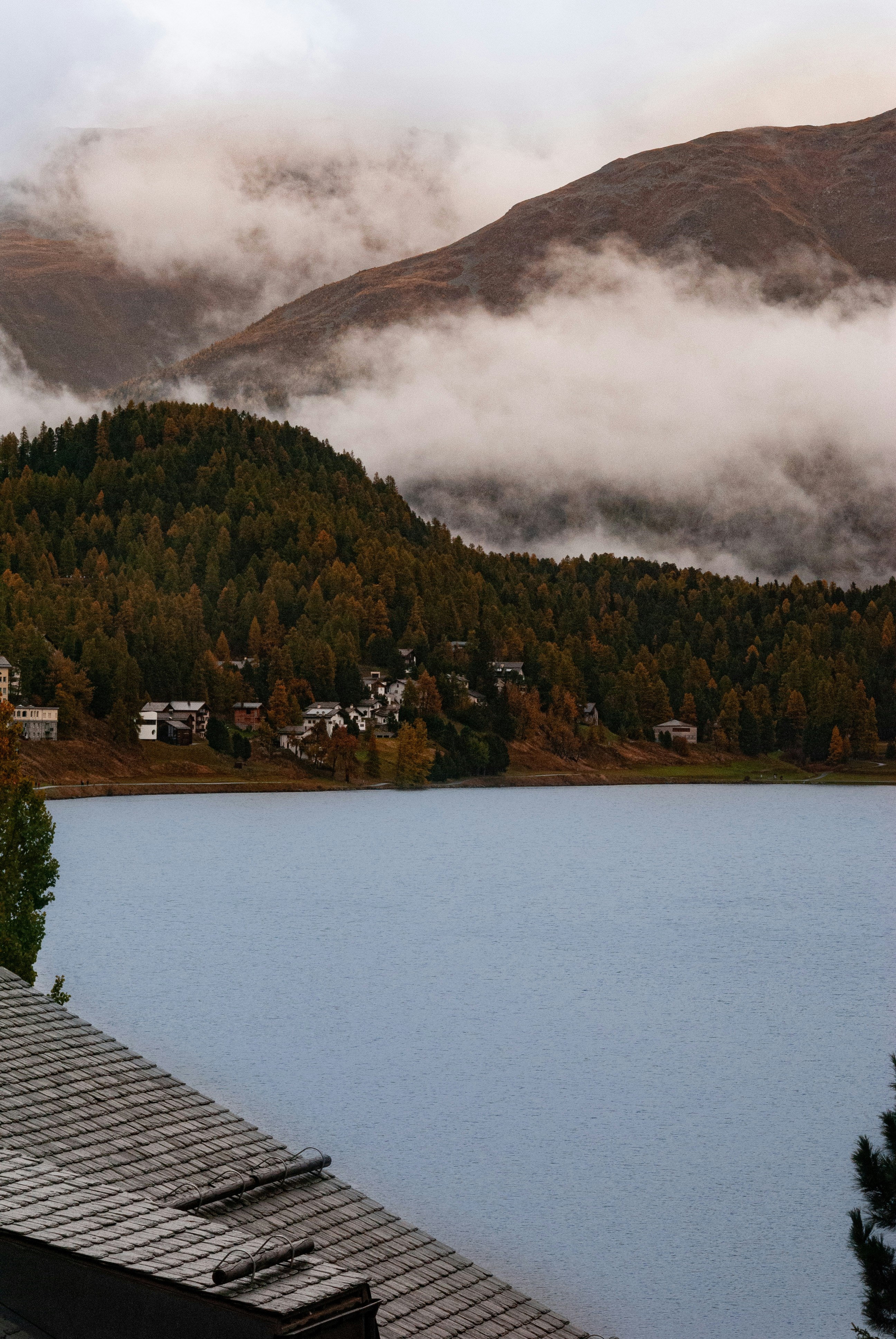 Mist-Kissed Village Cresting a Serene Lake