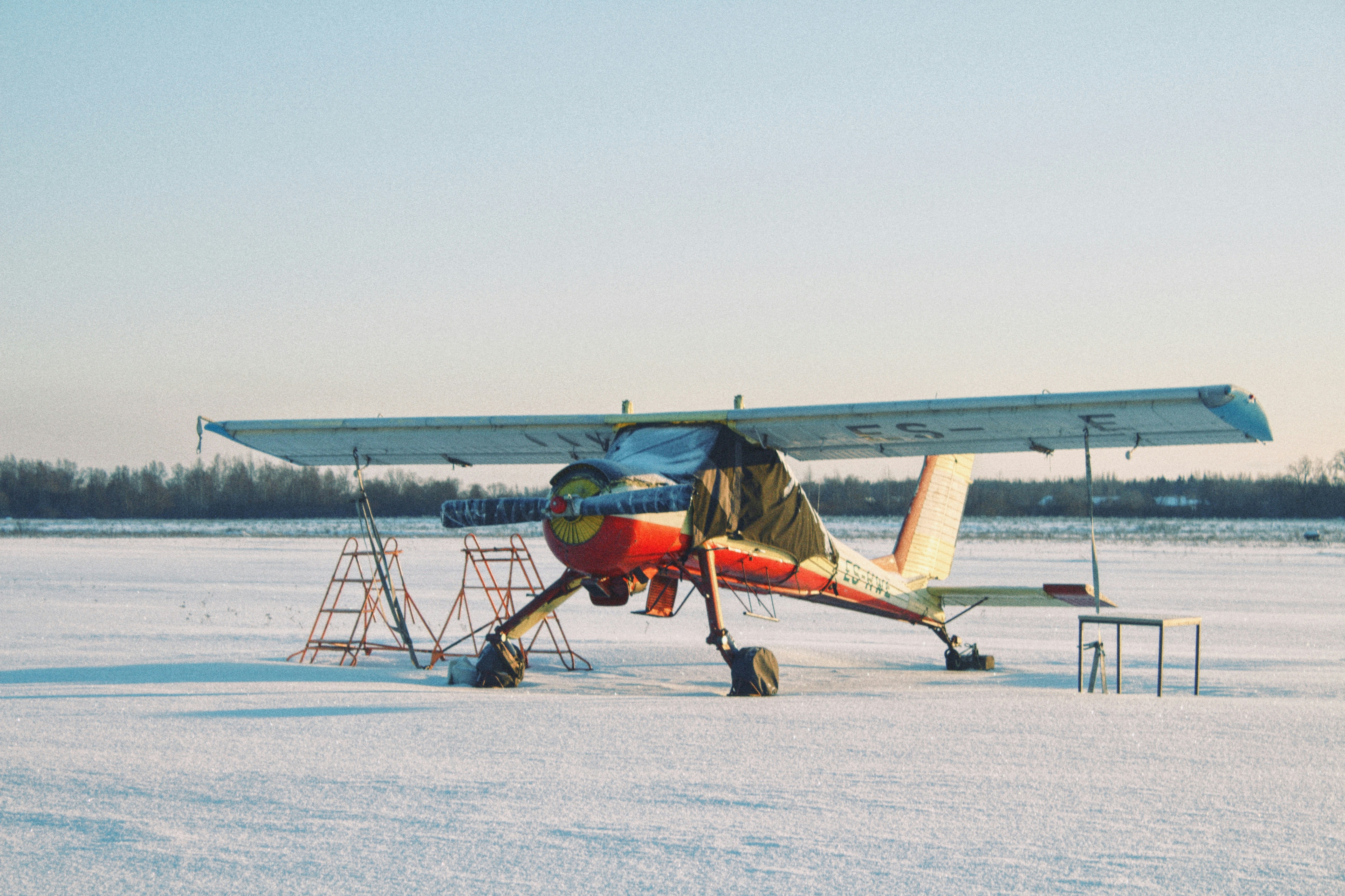 a small airplane sitting on top of a snow covered field
