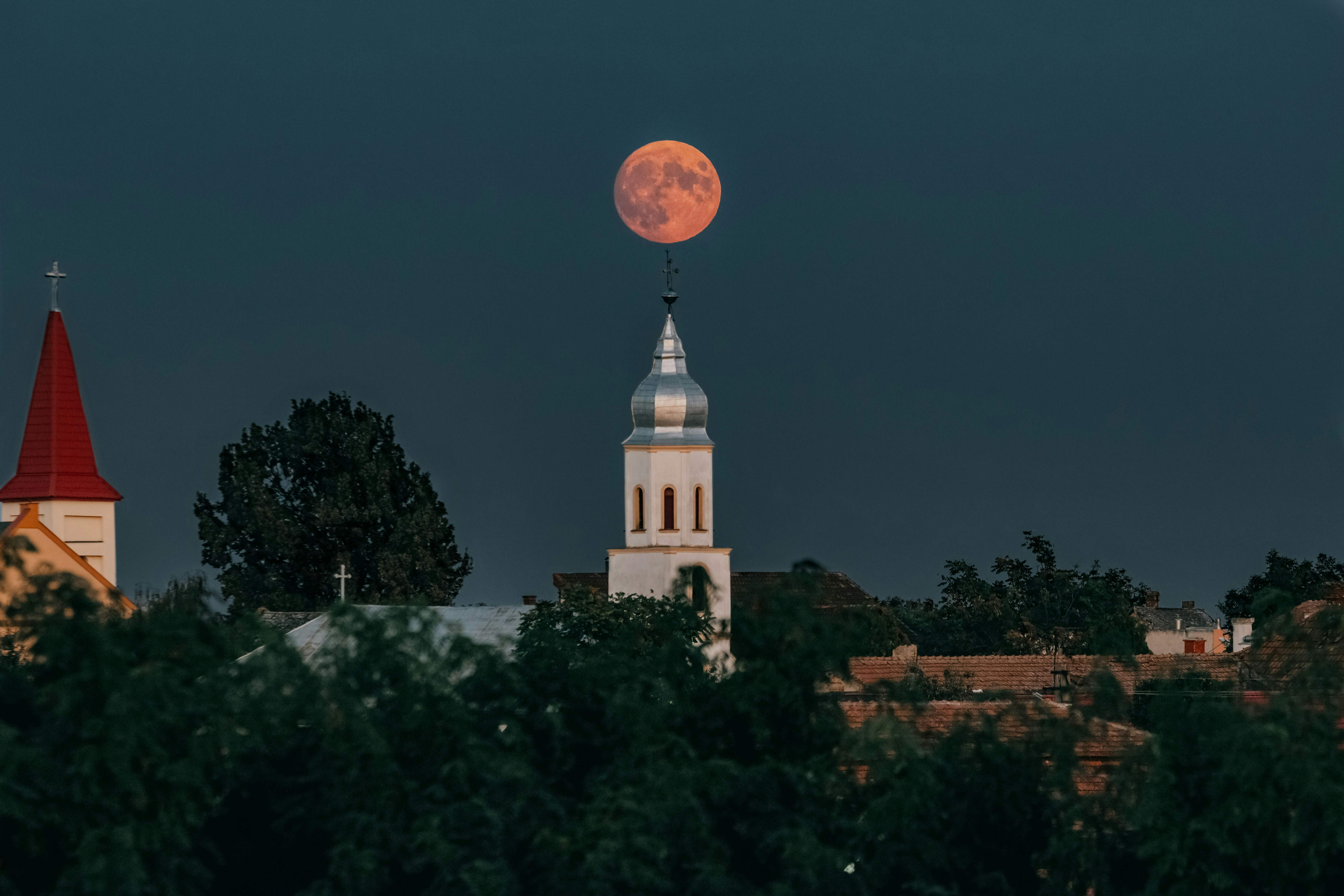 A full moon rising over a city with a church steeple photo – Free Moon ...