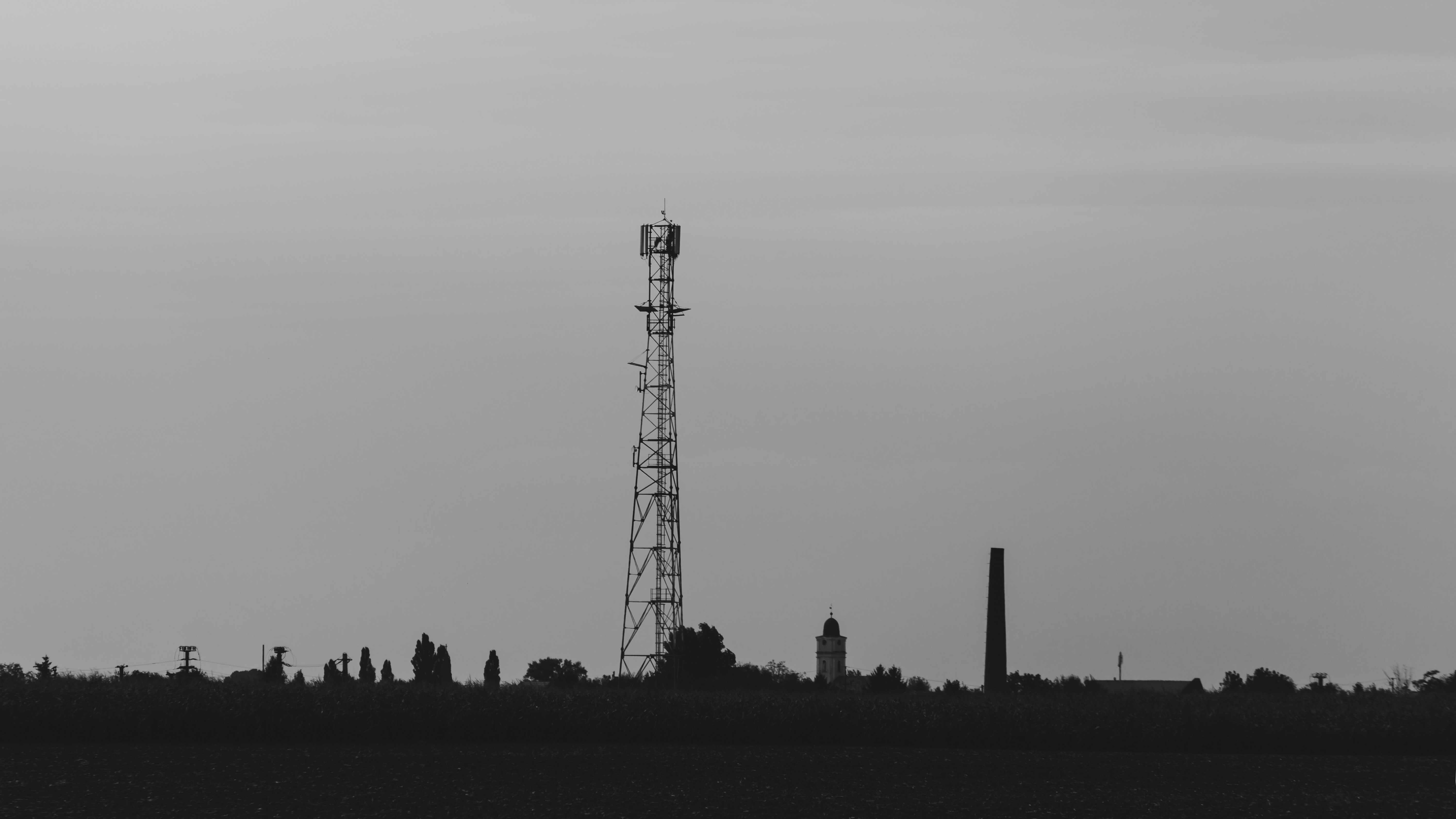 Lattice of Silence: A Lone Radio Mast on a Pale Horizon