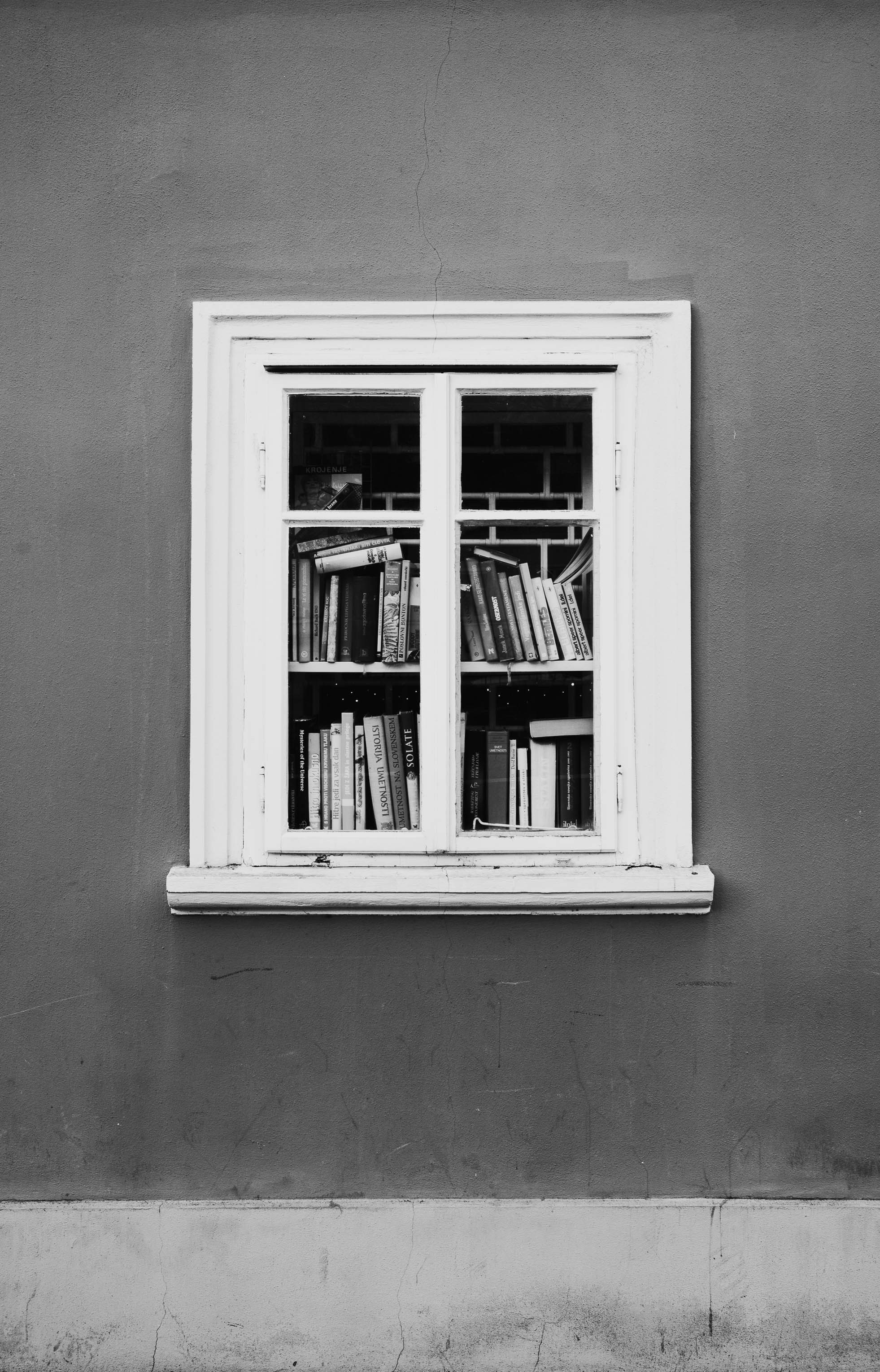 A black and white photo of a window with books photo – Free Ljubljana ...