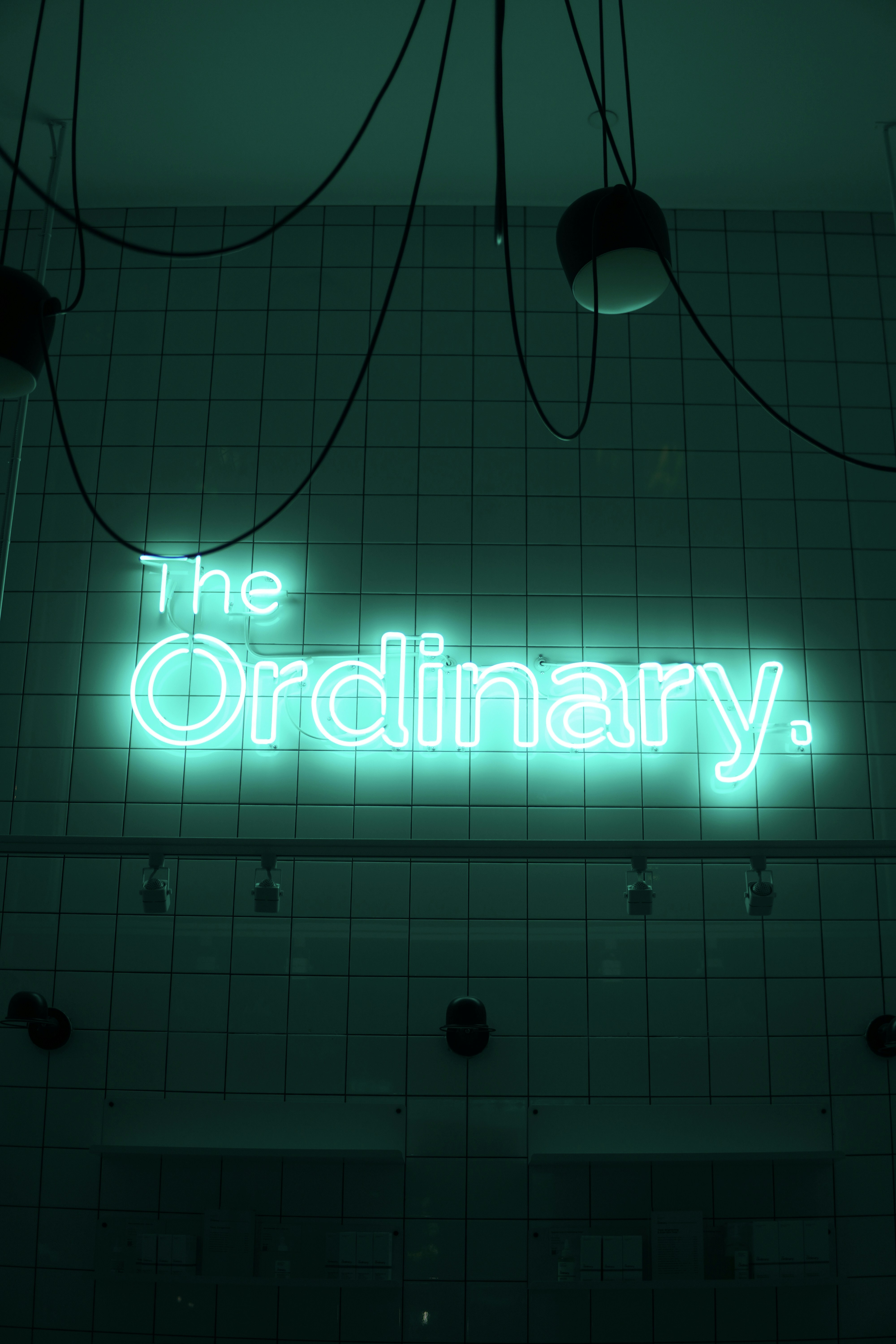 A neon sign that reads the ordinary above a tiled wall photo – Free ...