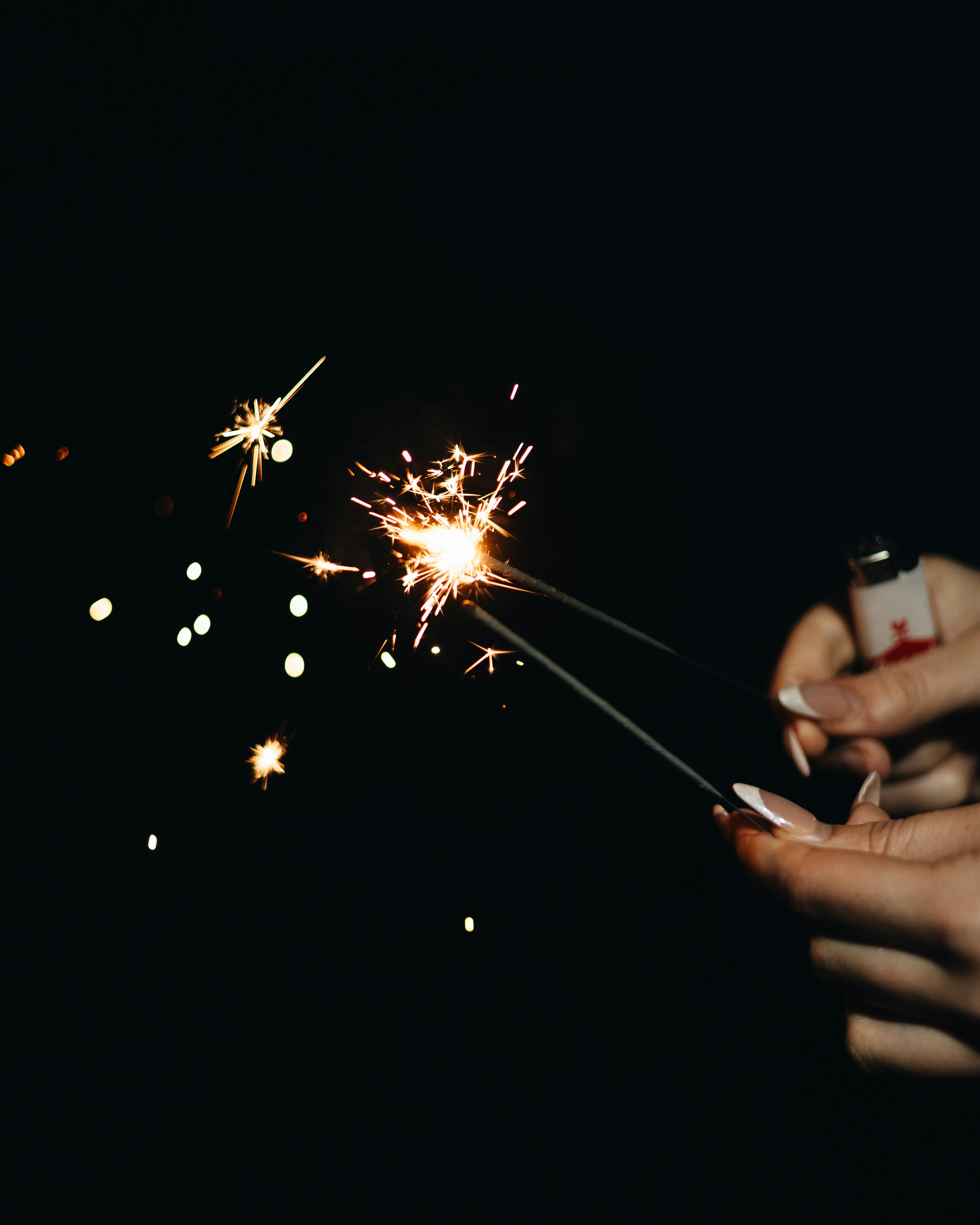 Midnight Sparks: A Close-Up of Firelight Between Gentle Hands