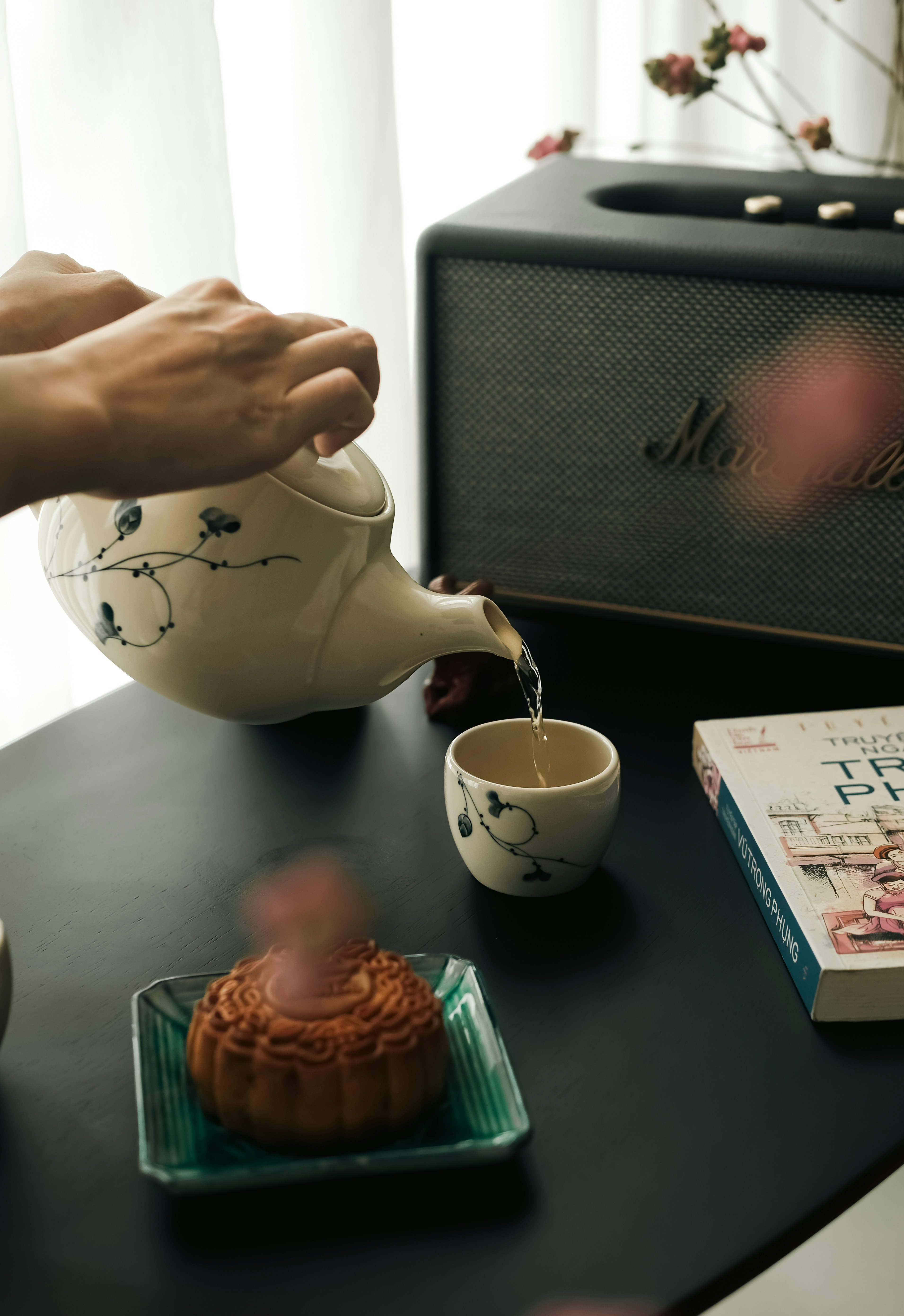 A person pours tea from a teapot into a cup photo – Free Ho chi minh Image on Unsplash