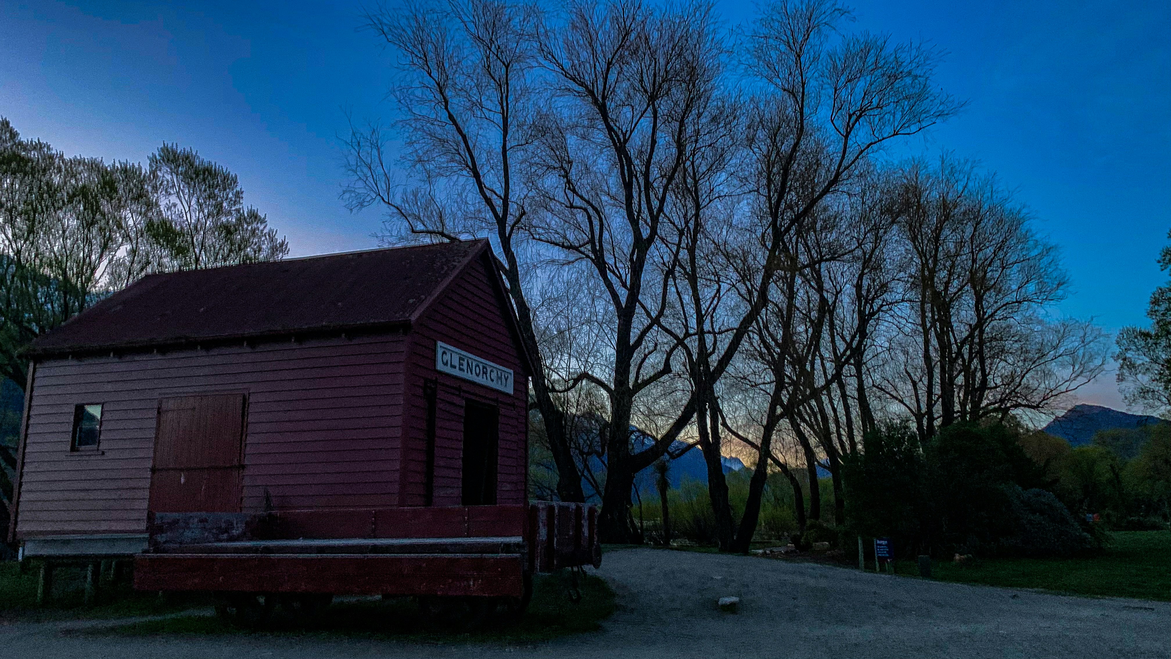 A small red building sitting in the middle of a forest photo – Free ...