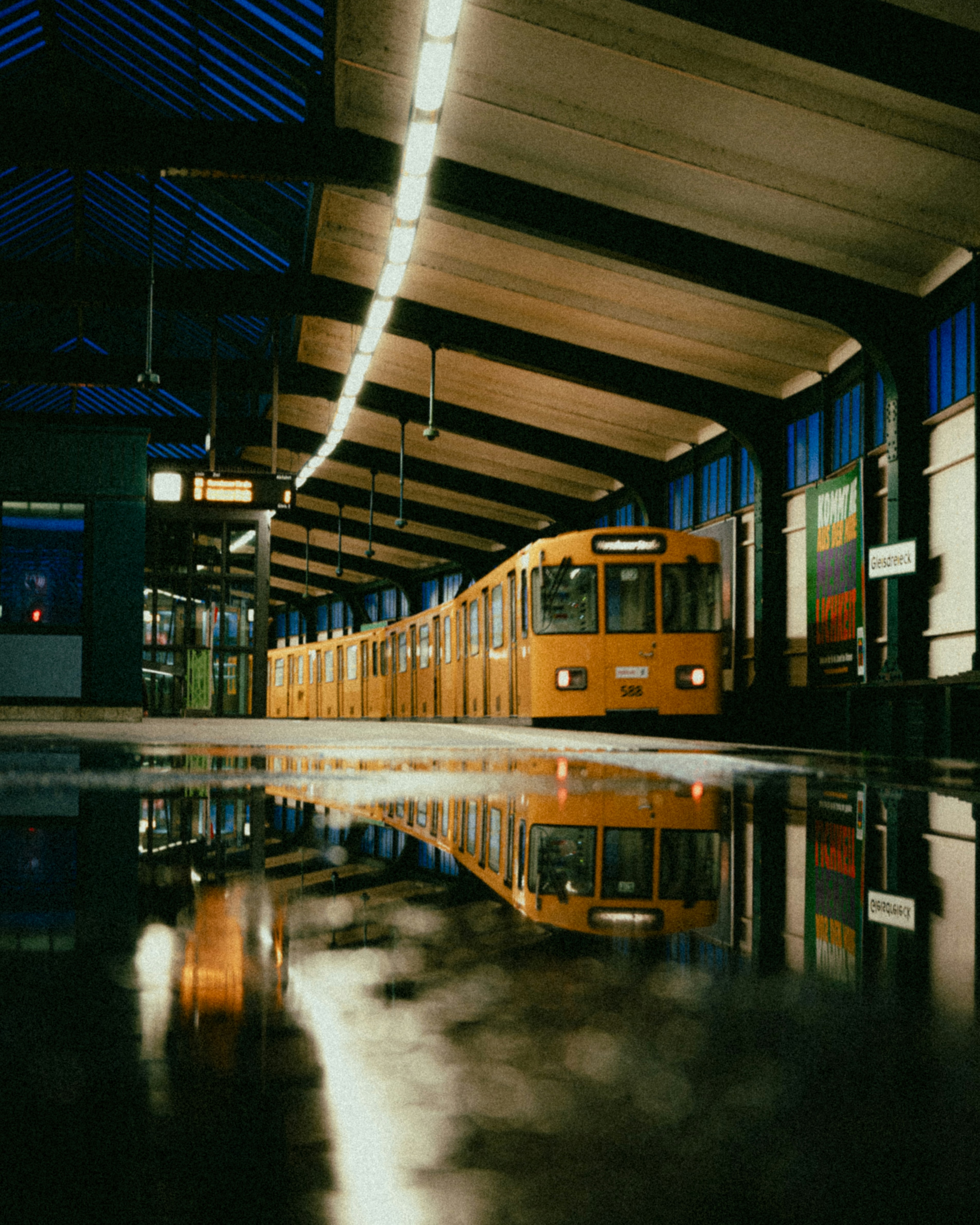 Quiet Orange Express on a Wet Platform: Reflections at Night