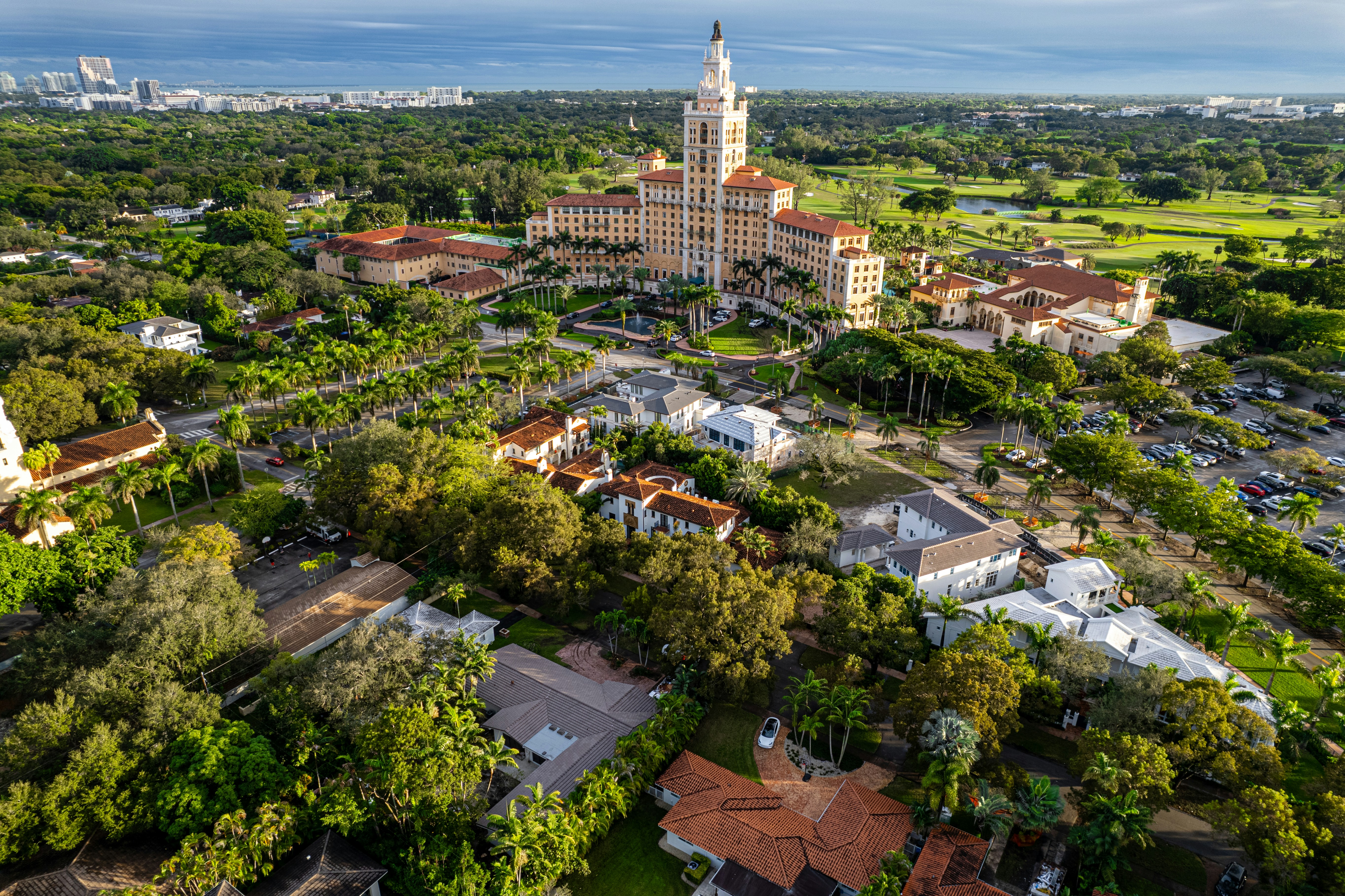 Aerial view of a grand historic building surrounded by lush greenery and urban landscape in Miami.